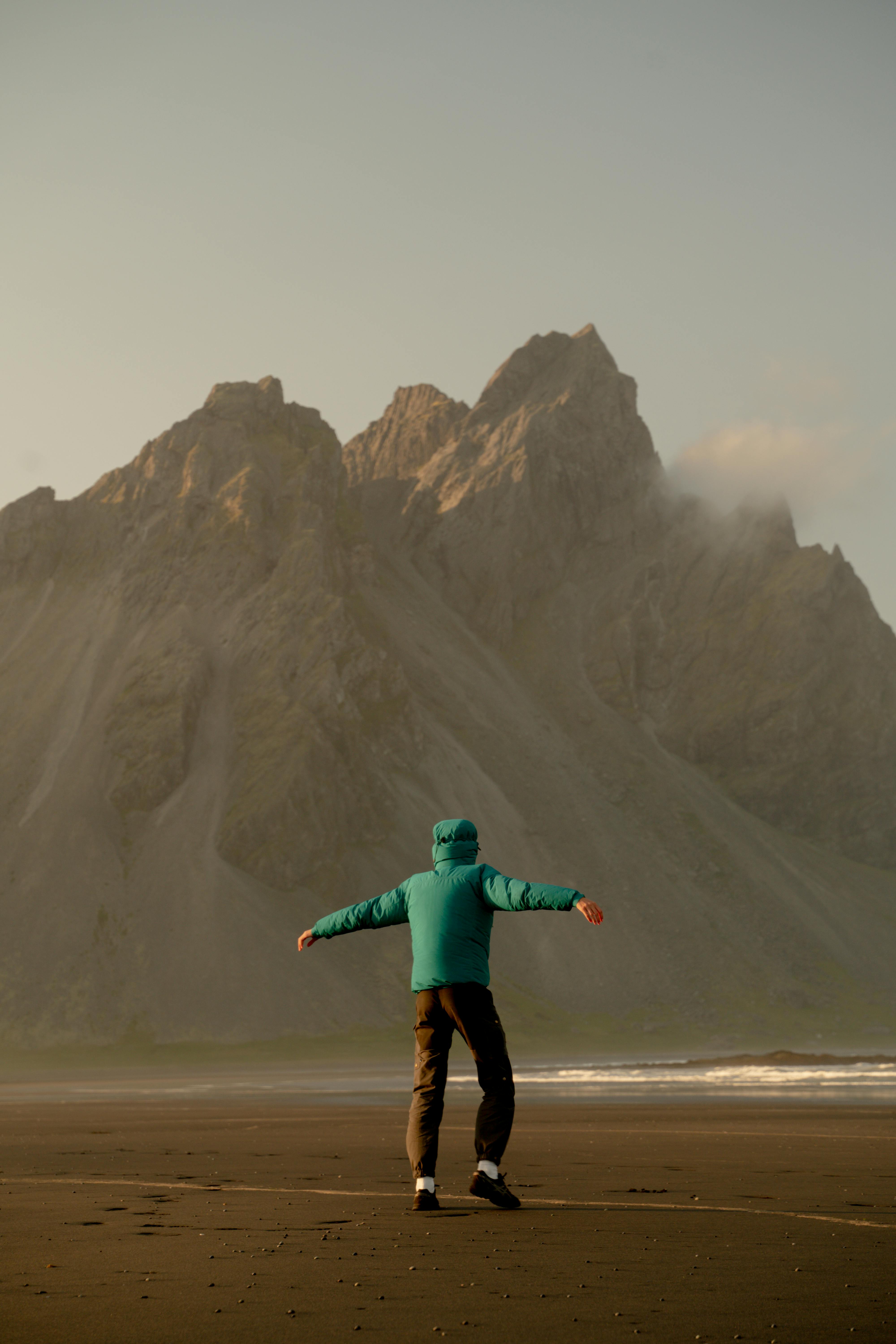 Adventurous Pose in Front of Icelandic Mountain · Free Stock Photo
