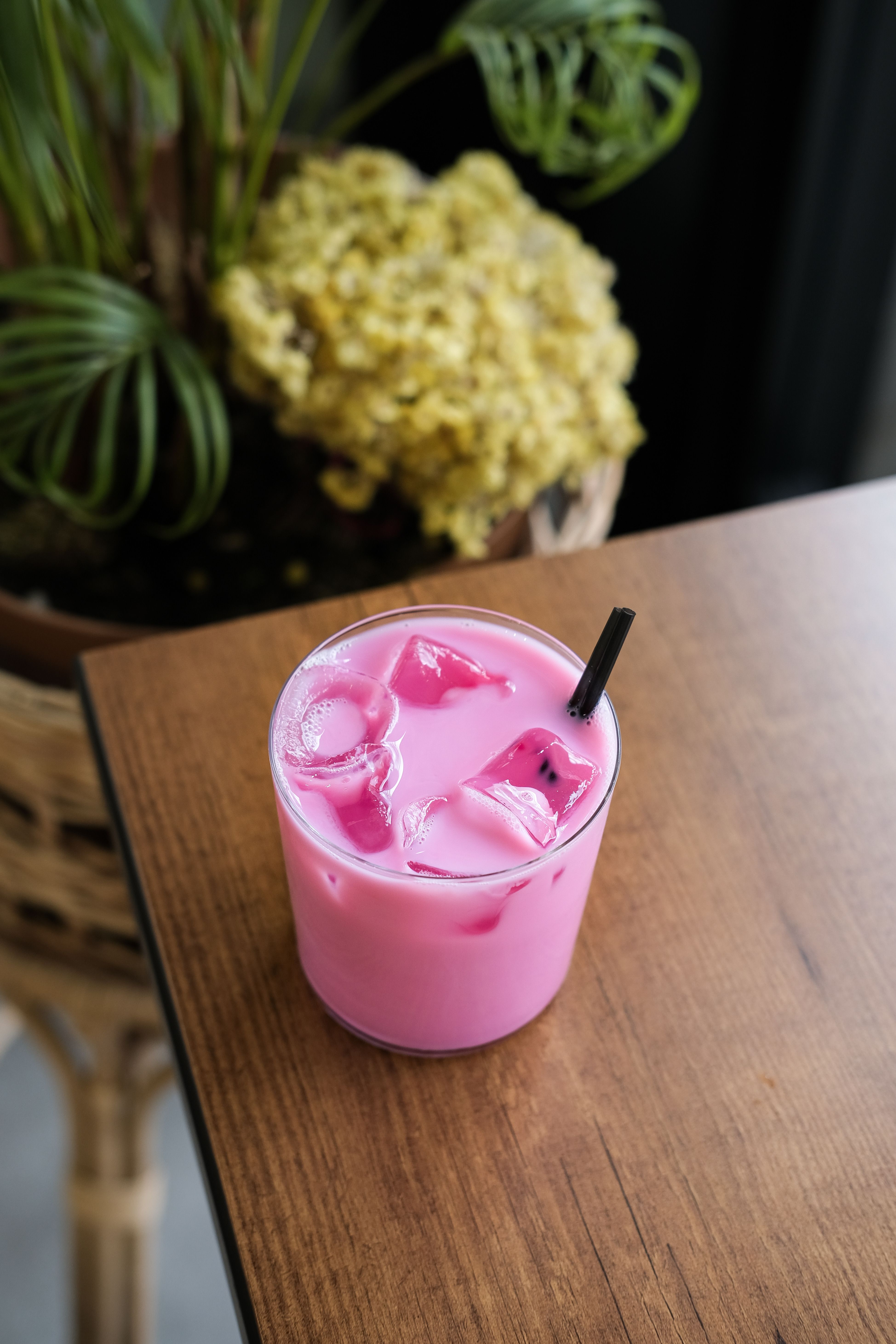 Vibrant Pink Iced Drink on Wooden Table · Free Stock Photo