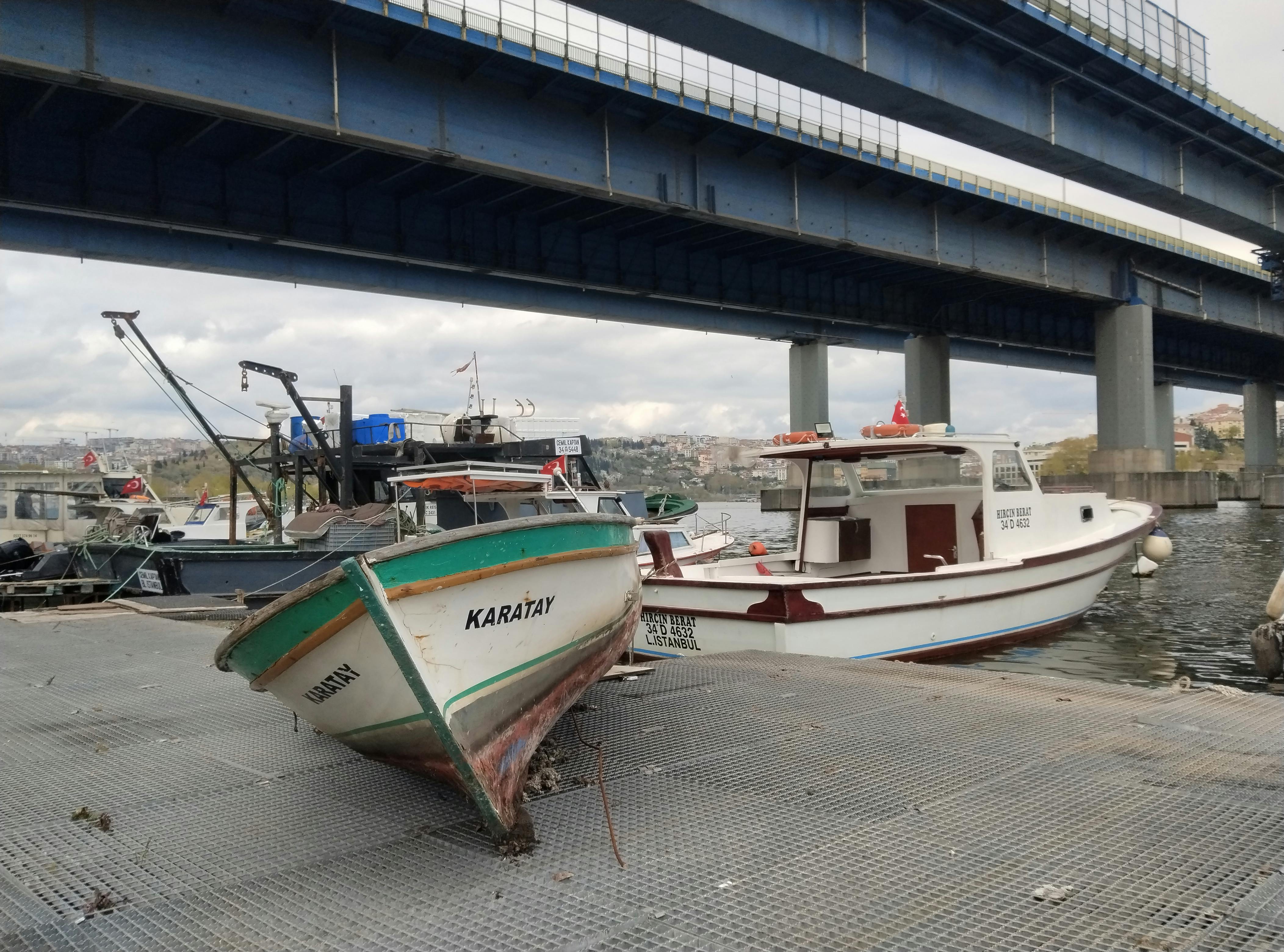 Small Boats Docked Under Bridge in Istanbul Harbor · Free Stock Photo