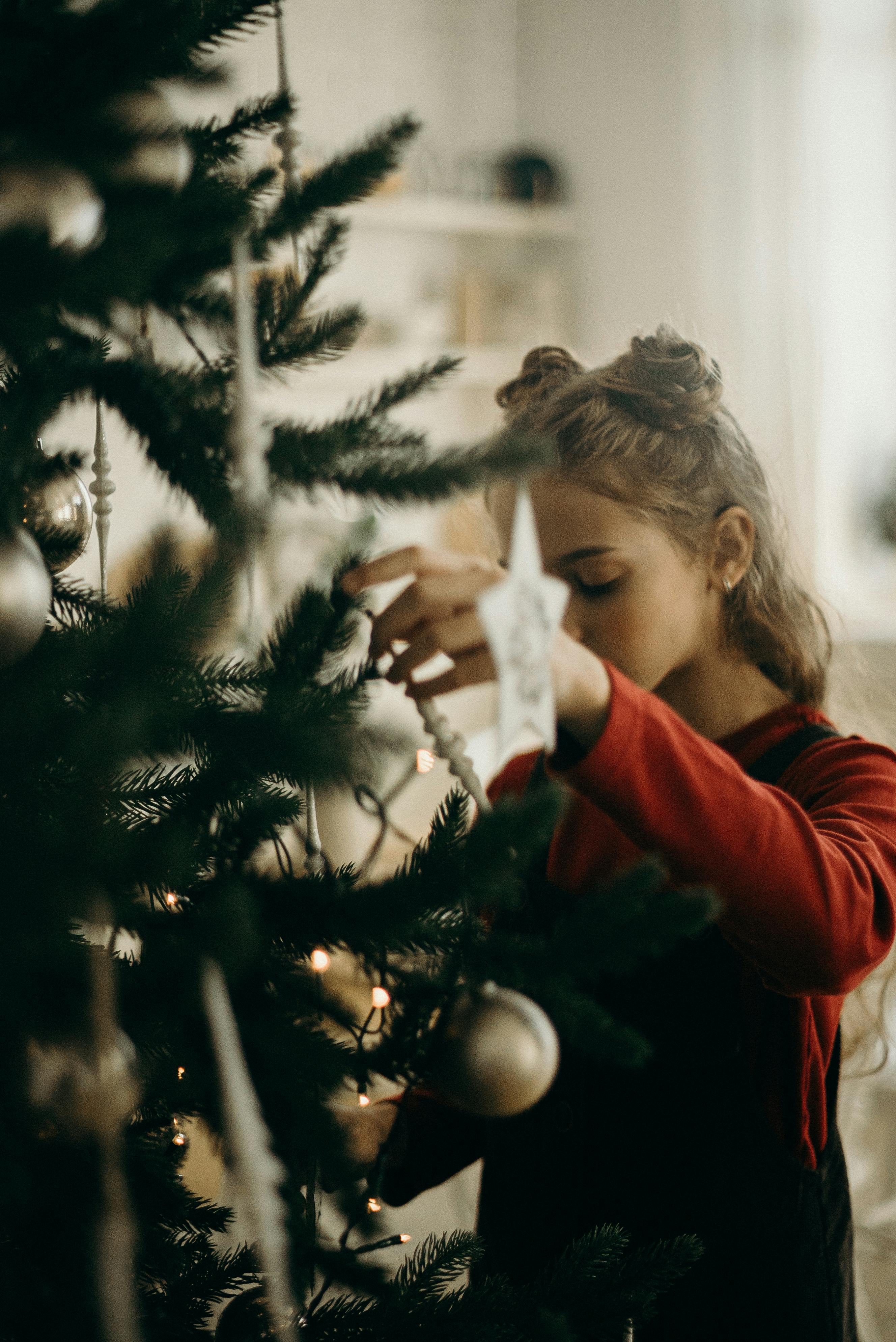 Person Decorating A Christmas Tree · Free Stock Photo