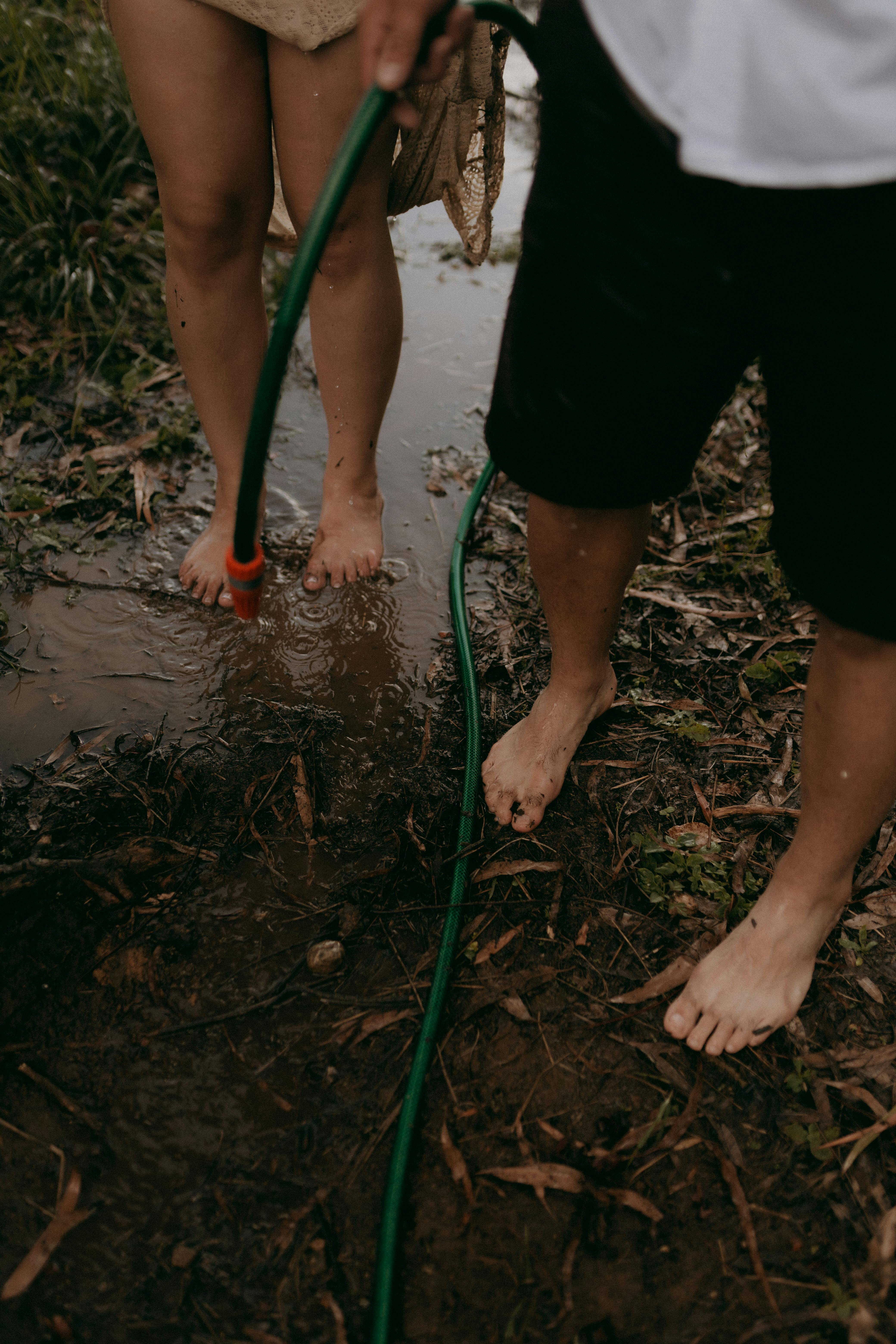 Barefoot People Watering Soil with Garden Hose · Free Stock Photo