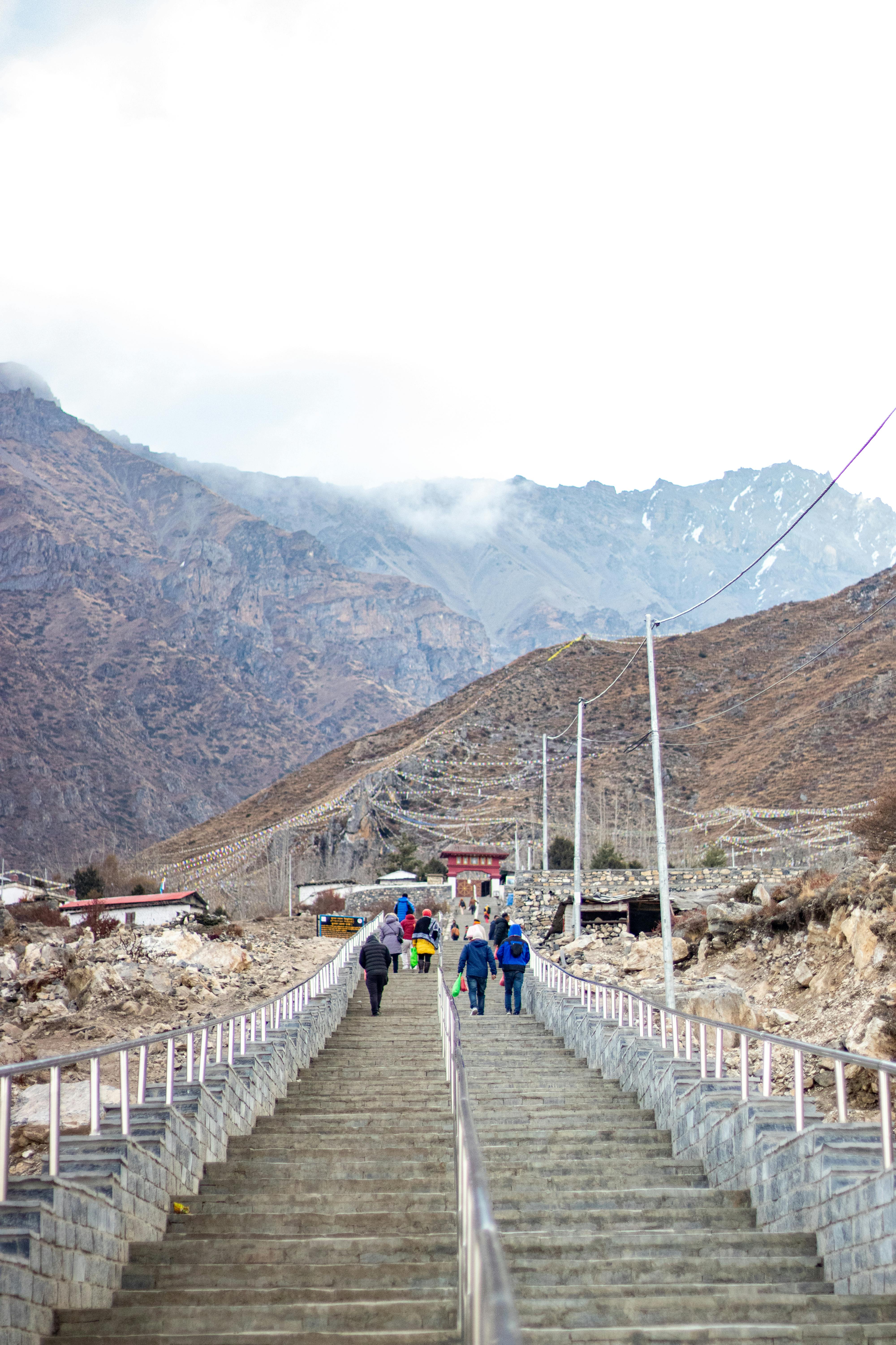 Hikers Ascend Mountain Steps in Scenic Landscape · Free Stock Photo