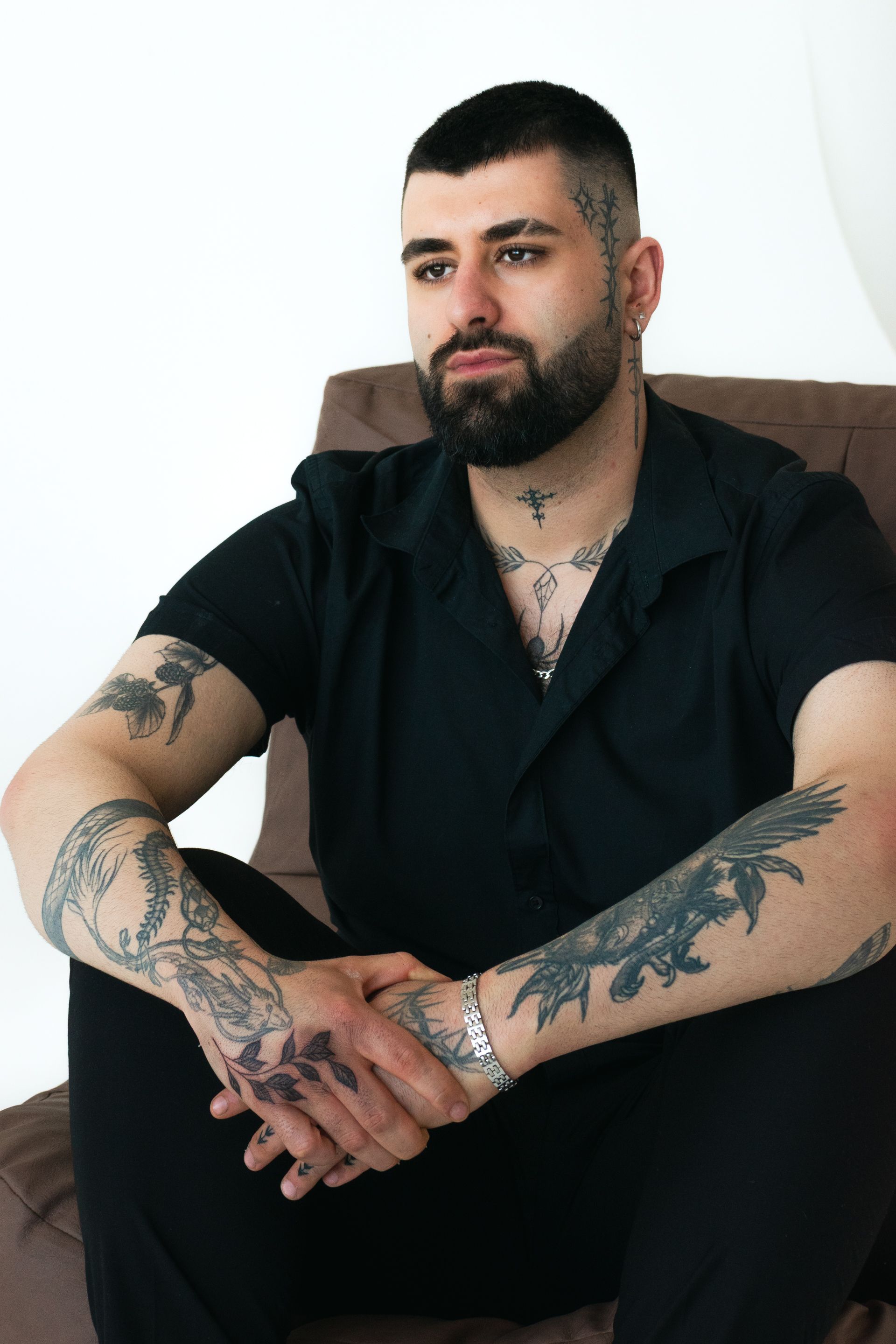 Tattooed Male Model in a Relaxed Pose Indoors · Free Stock Photo