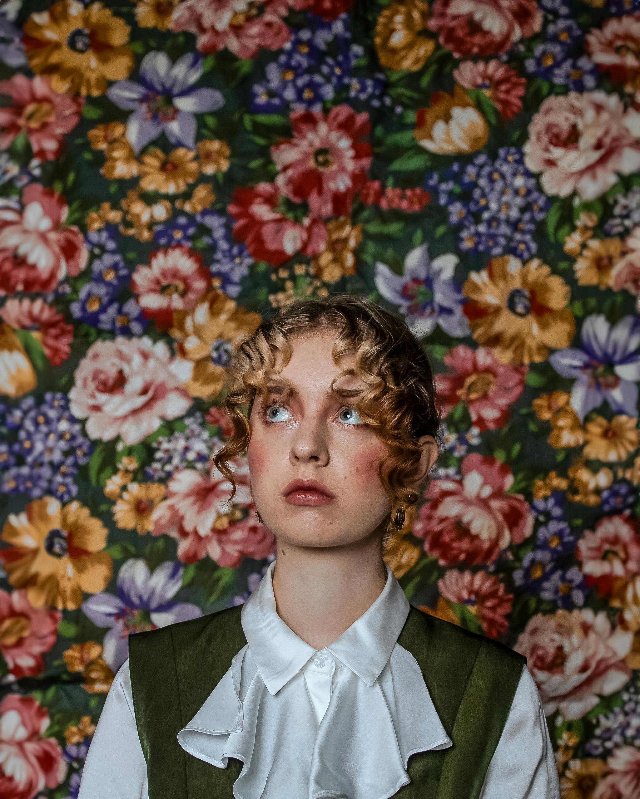 Portrait of Woman Against Vibrant Floral Background · Free Stock Photo