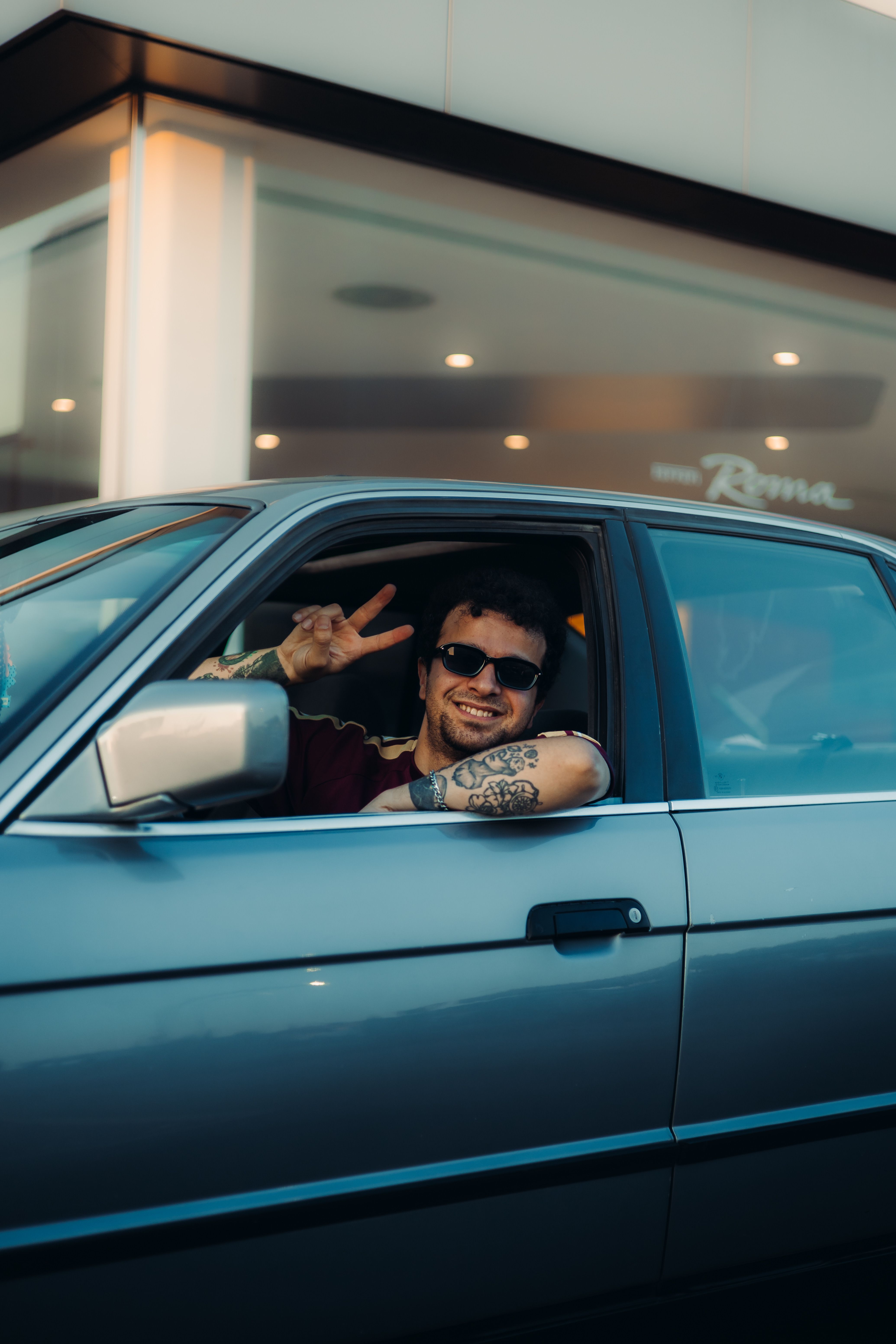 Man Showing Peace Sign from Classic Car Window · Free Stock Photo