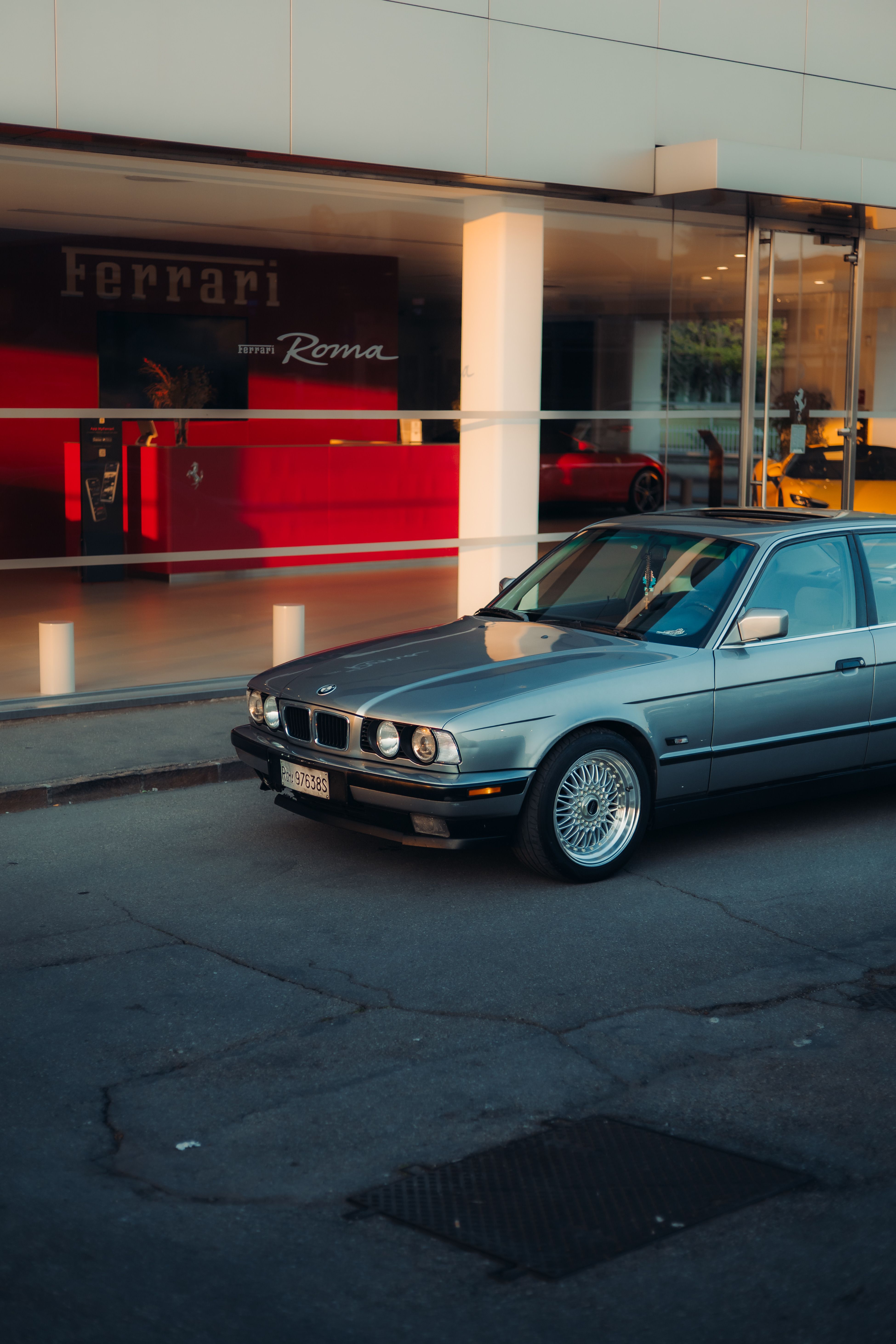Classic Car Parked Outside Ferrari Dealership · Free Stock Photo