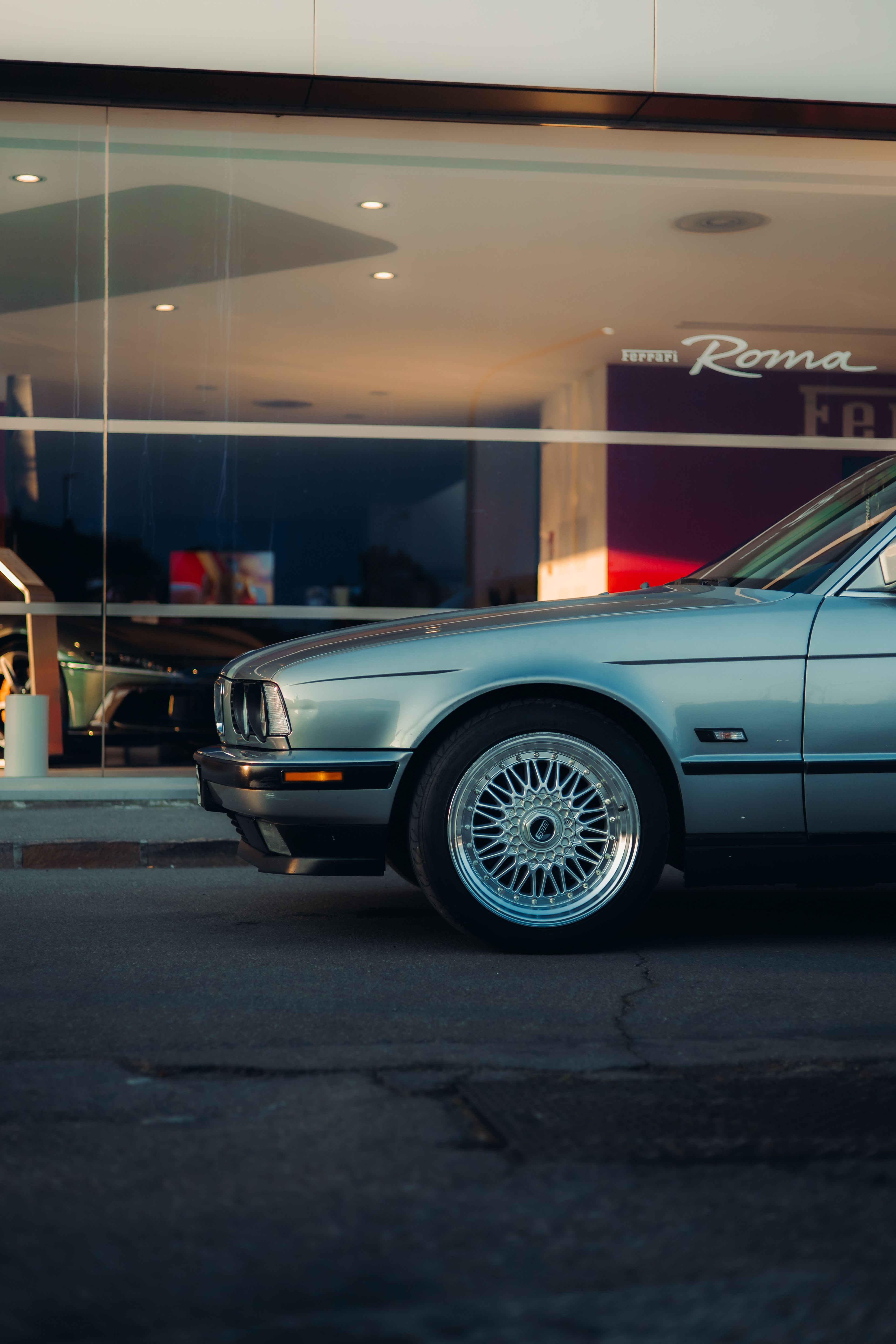 Classic car parked outside luxury dealership at dusk · Free Stock Photo