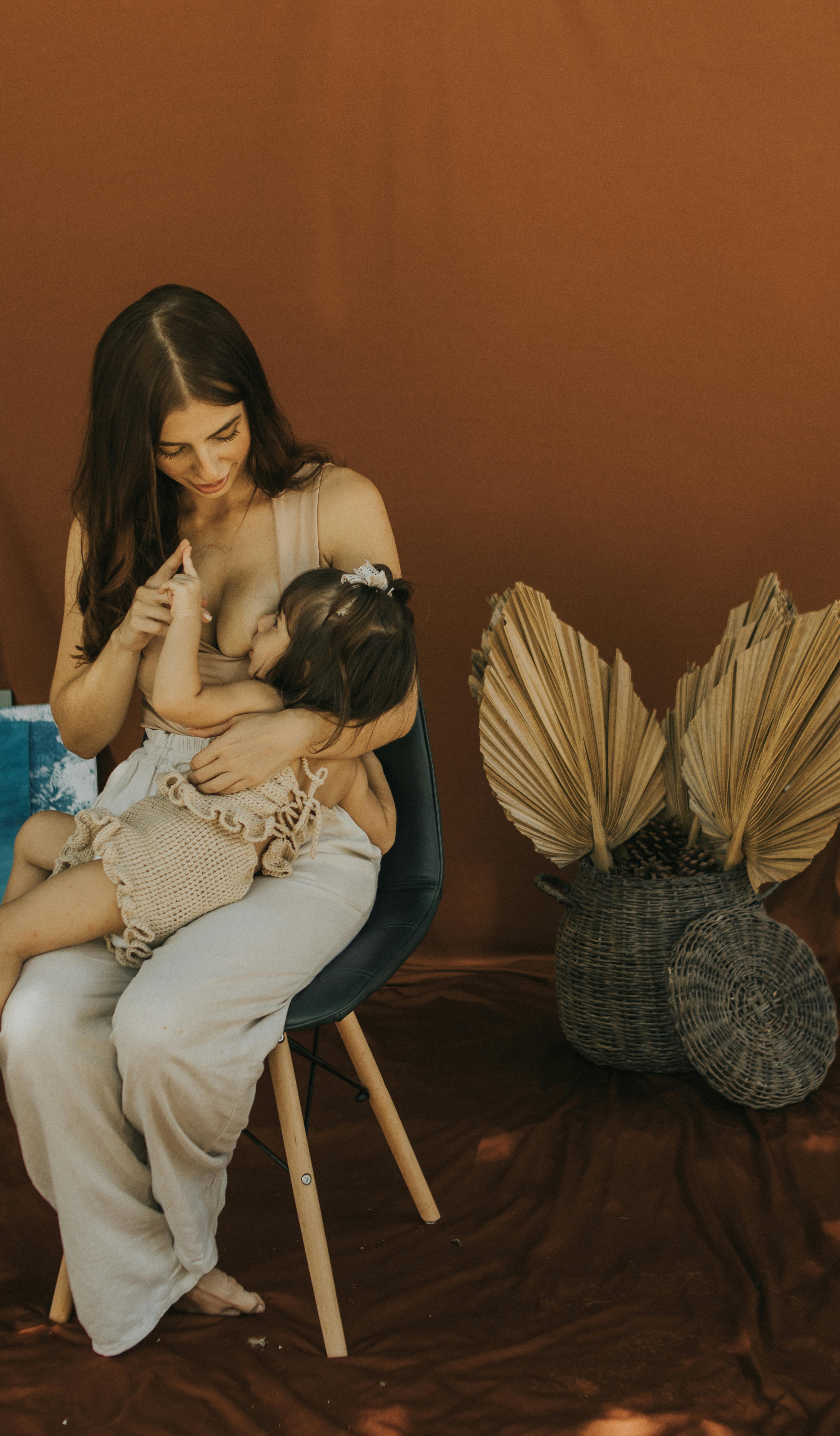 Mother Breastfeeding Child in Natural Setting · Free Stock Photo