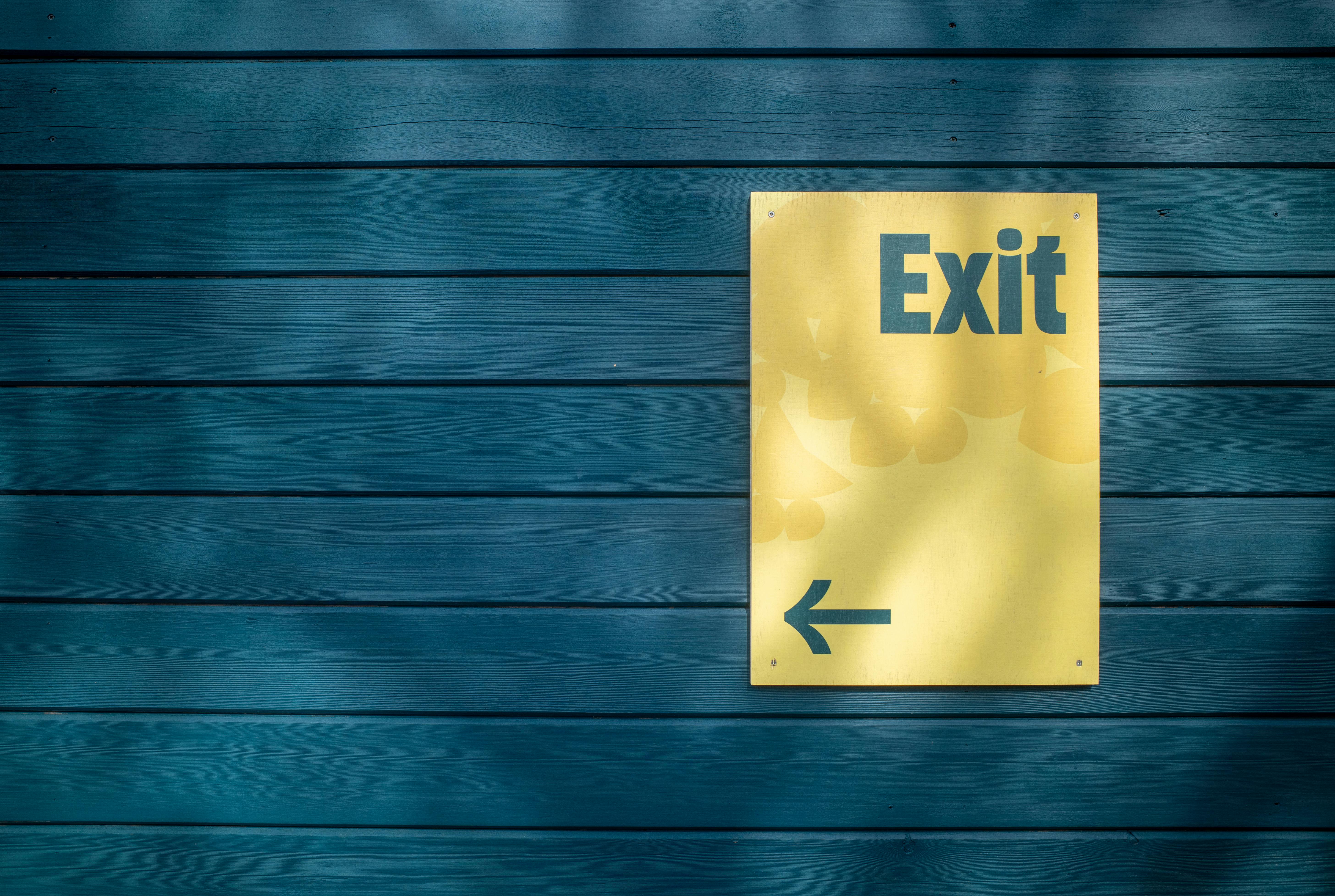 Yellow Exit Sign on Blue Wooden Wall · Free Stock Photo