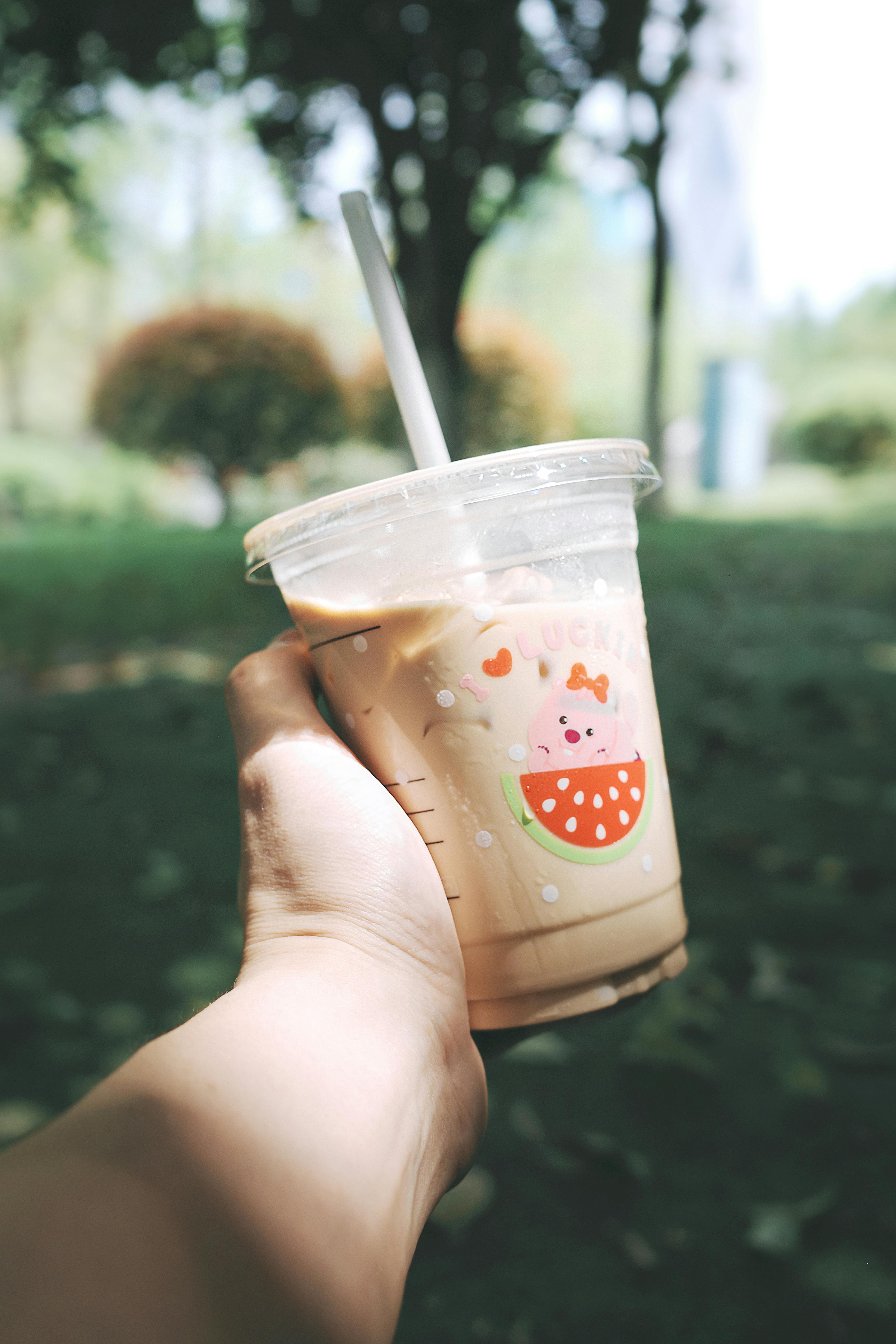 Refreshing Iced Coffee Cup Held Outdoors · Free Stock Photo