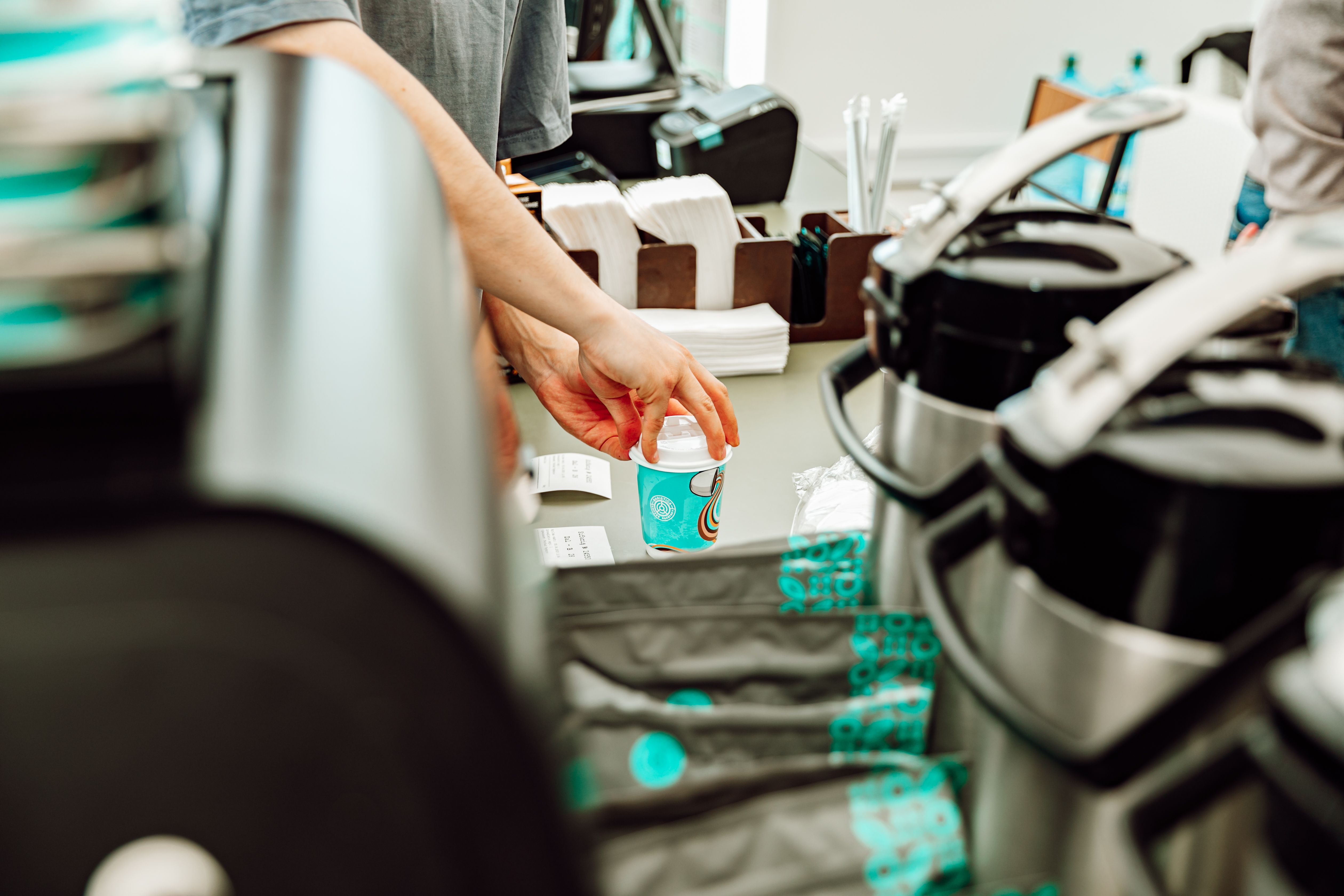 Person Serving Coffee at a Modern Café · Free Stock Photo