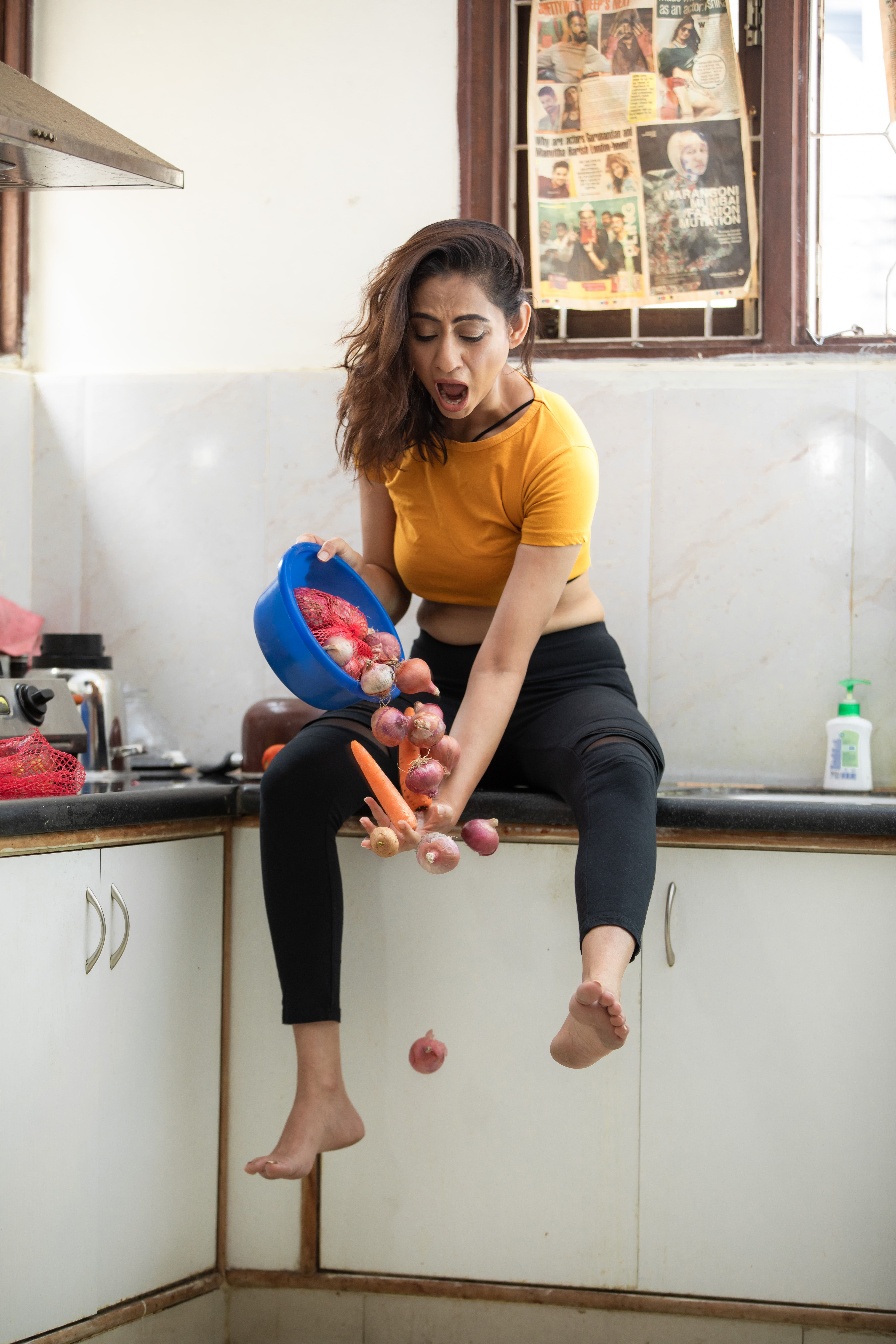 Surprised Woman Dropping Vegetables in Kitchen · Free Stock Photo