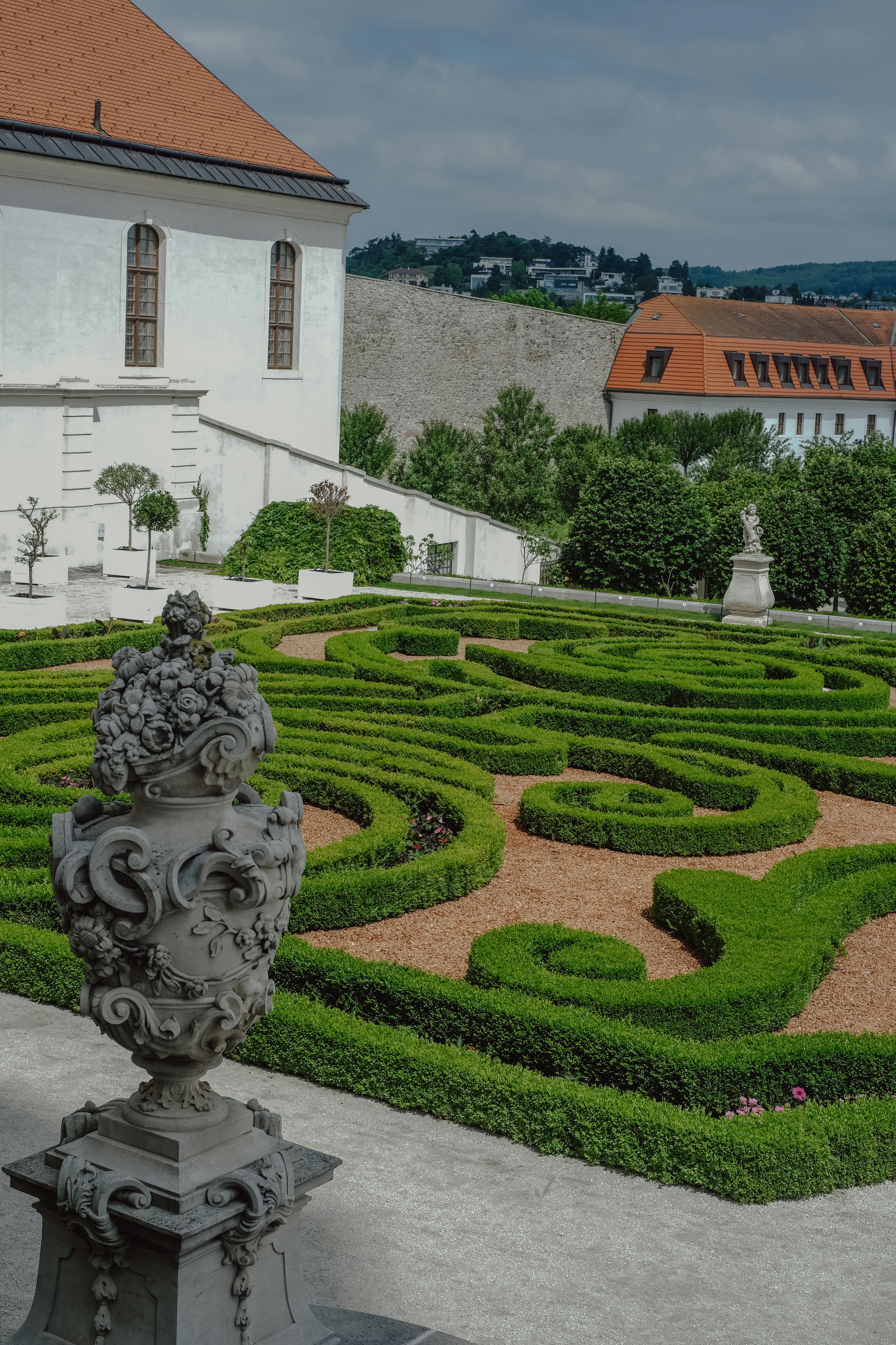 Intricate Garden Maze Adjacent to Baroque Architecture · Free Stock Photo