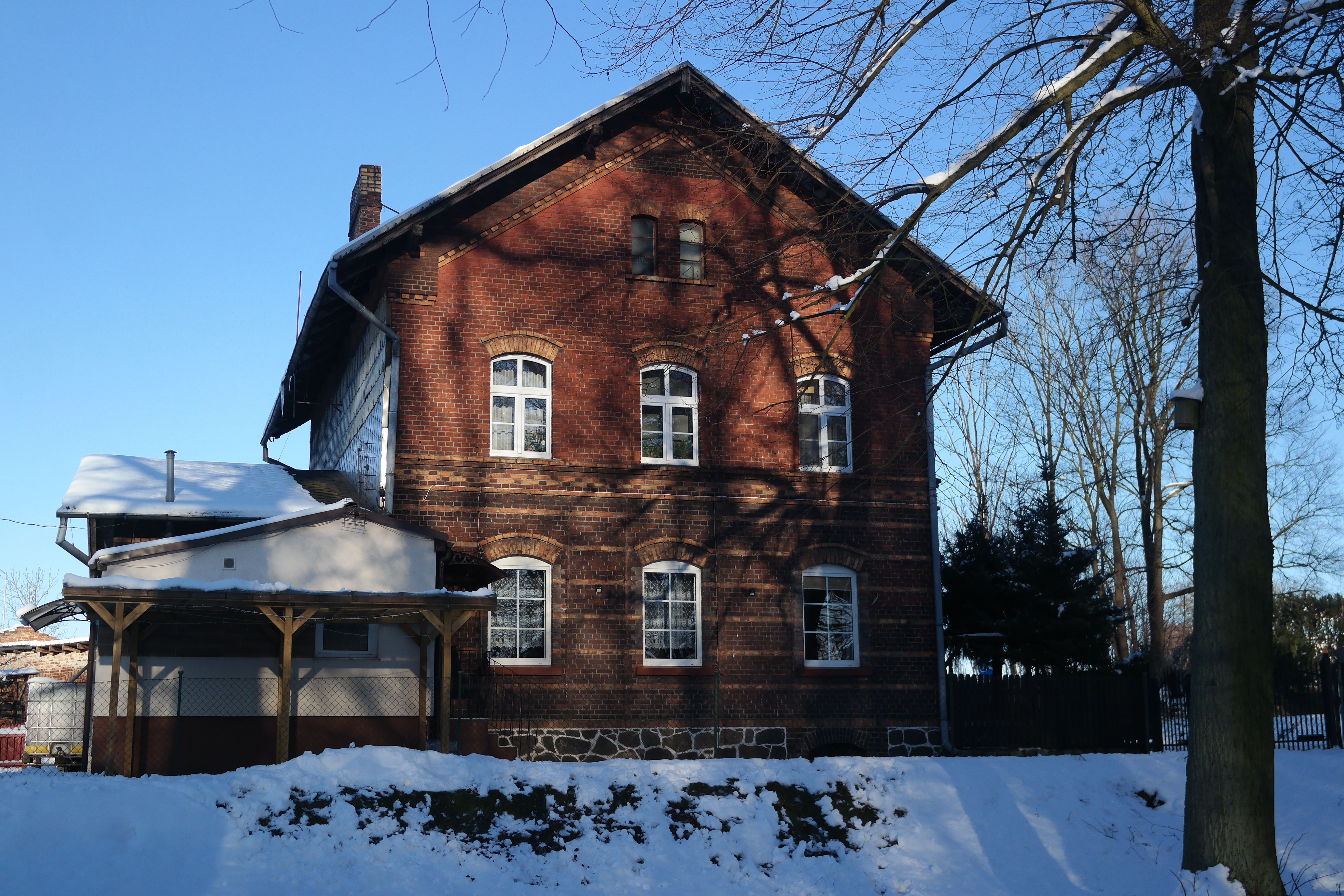 Snow-Covered Historic Brick Building in Winter Sun · Free Stock Photo