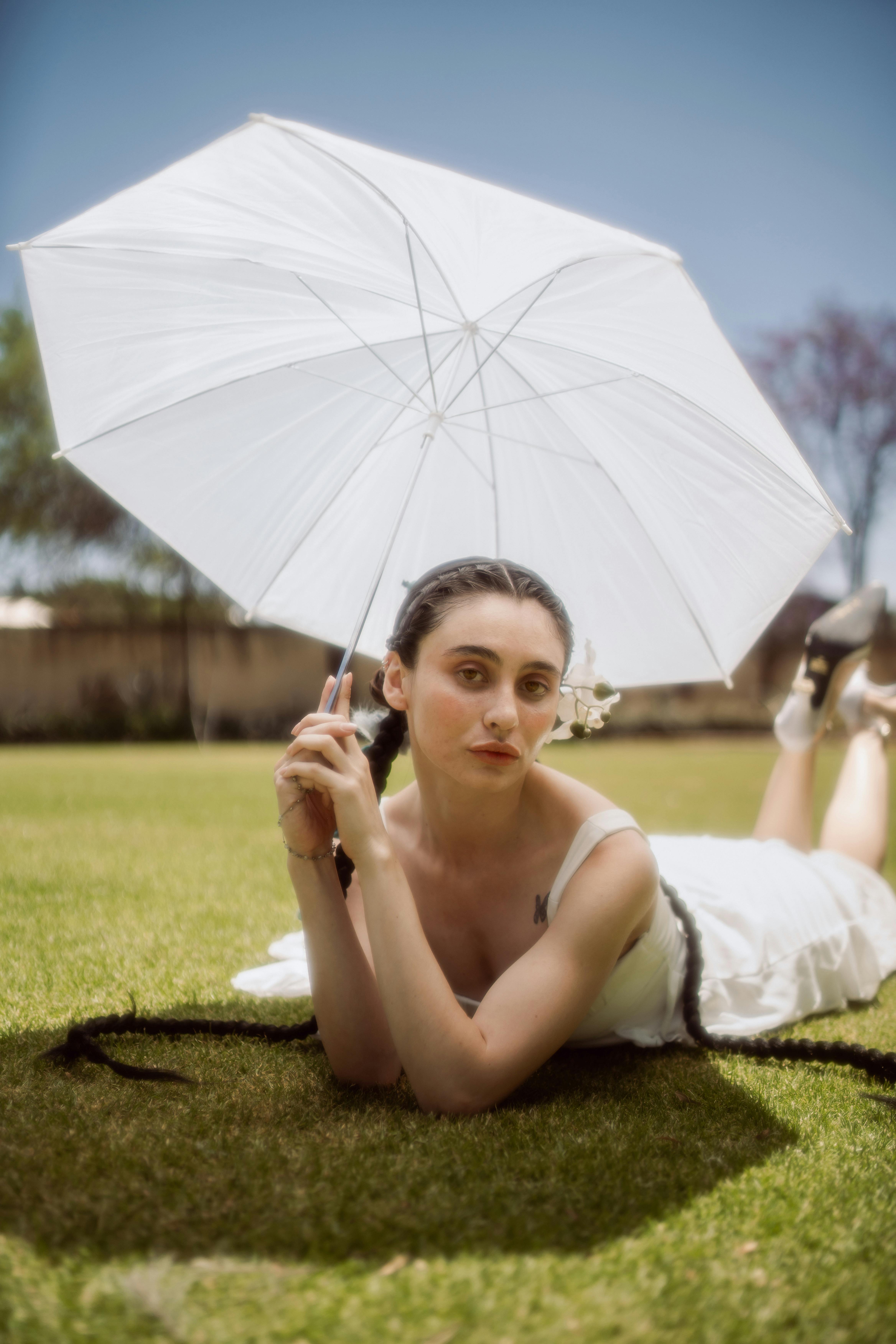 Bride Relaxing with Umbrella on Sunny Day · Free Stock Photo