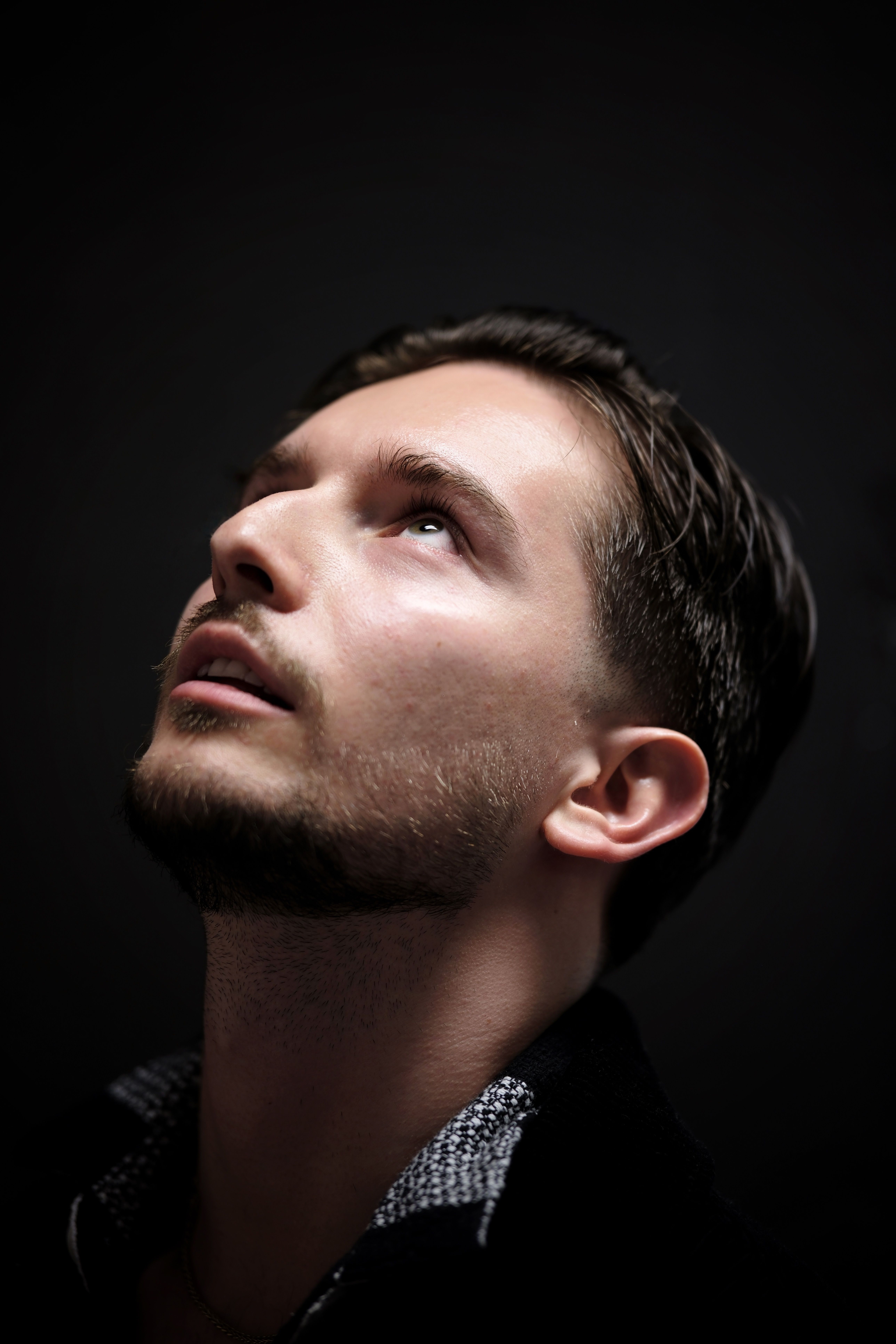 Contemplative Portrait of a Young Man in Low Light · Free Stock Photo