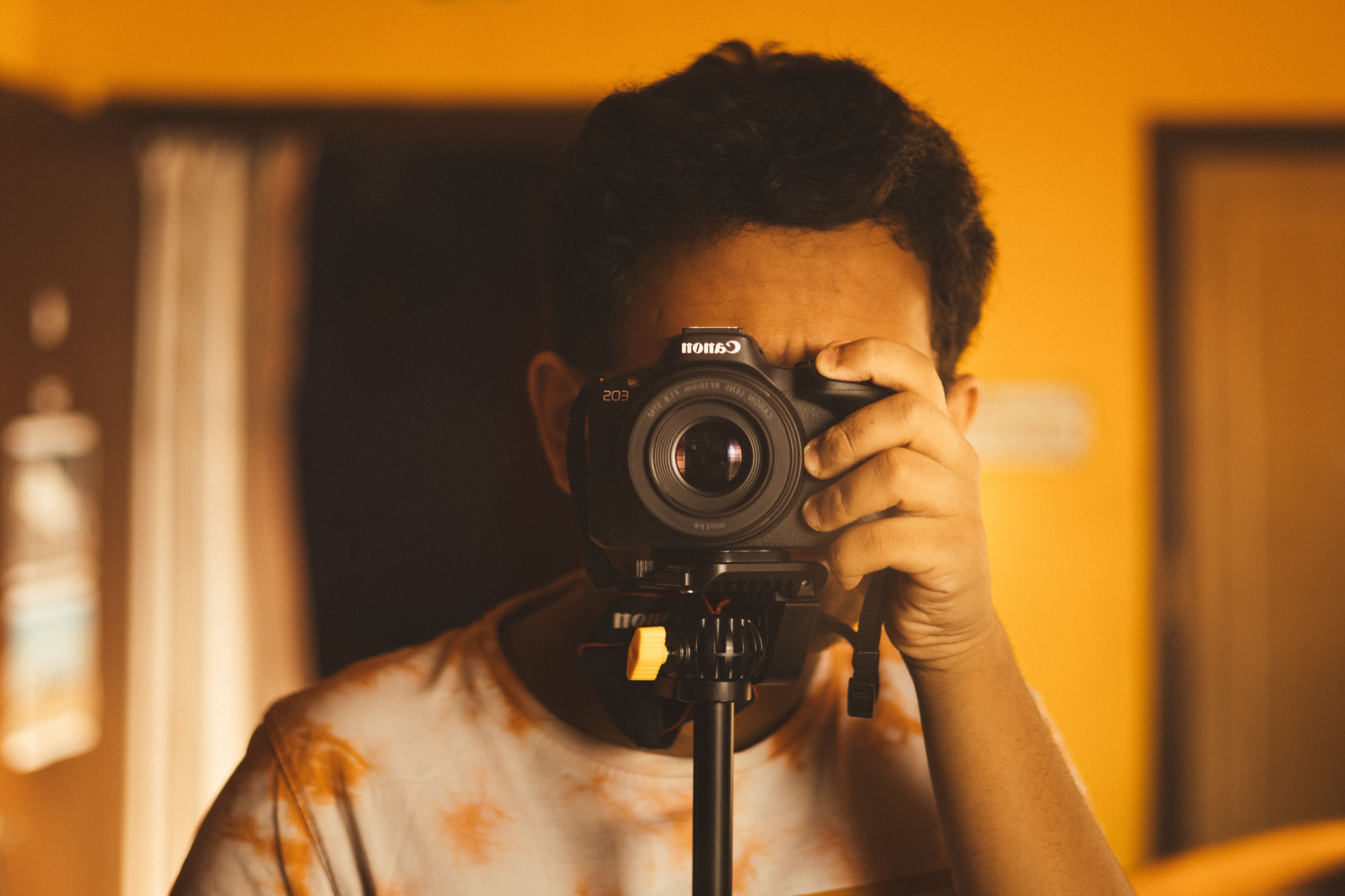 Young Photographer Taking a Self-Portrait Indoors · Free Stock Photo