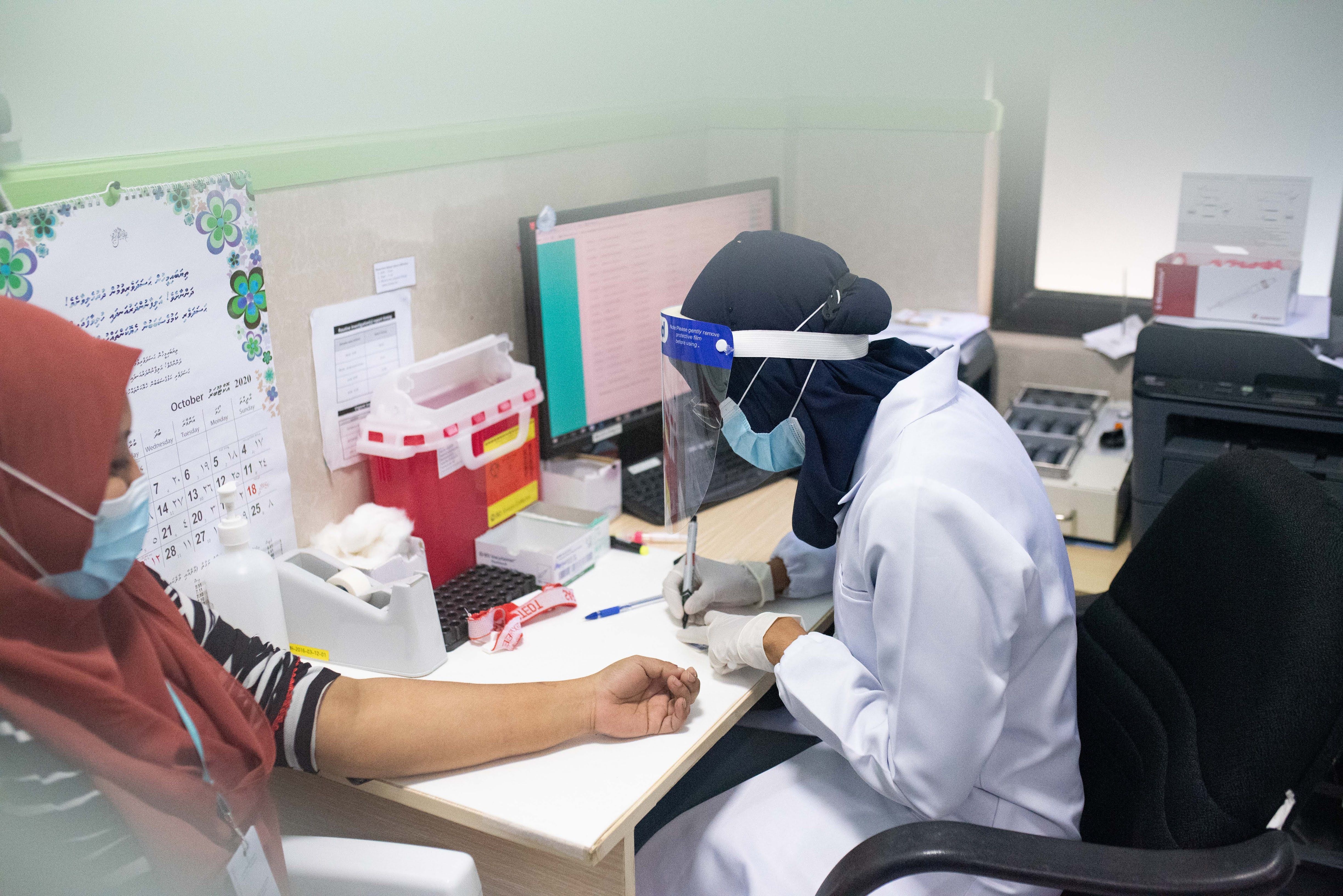 Healthcare Worker Drawing Blood in a Medical Office · Free Stock Photo