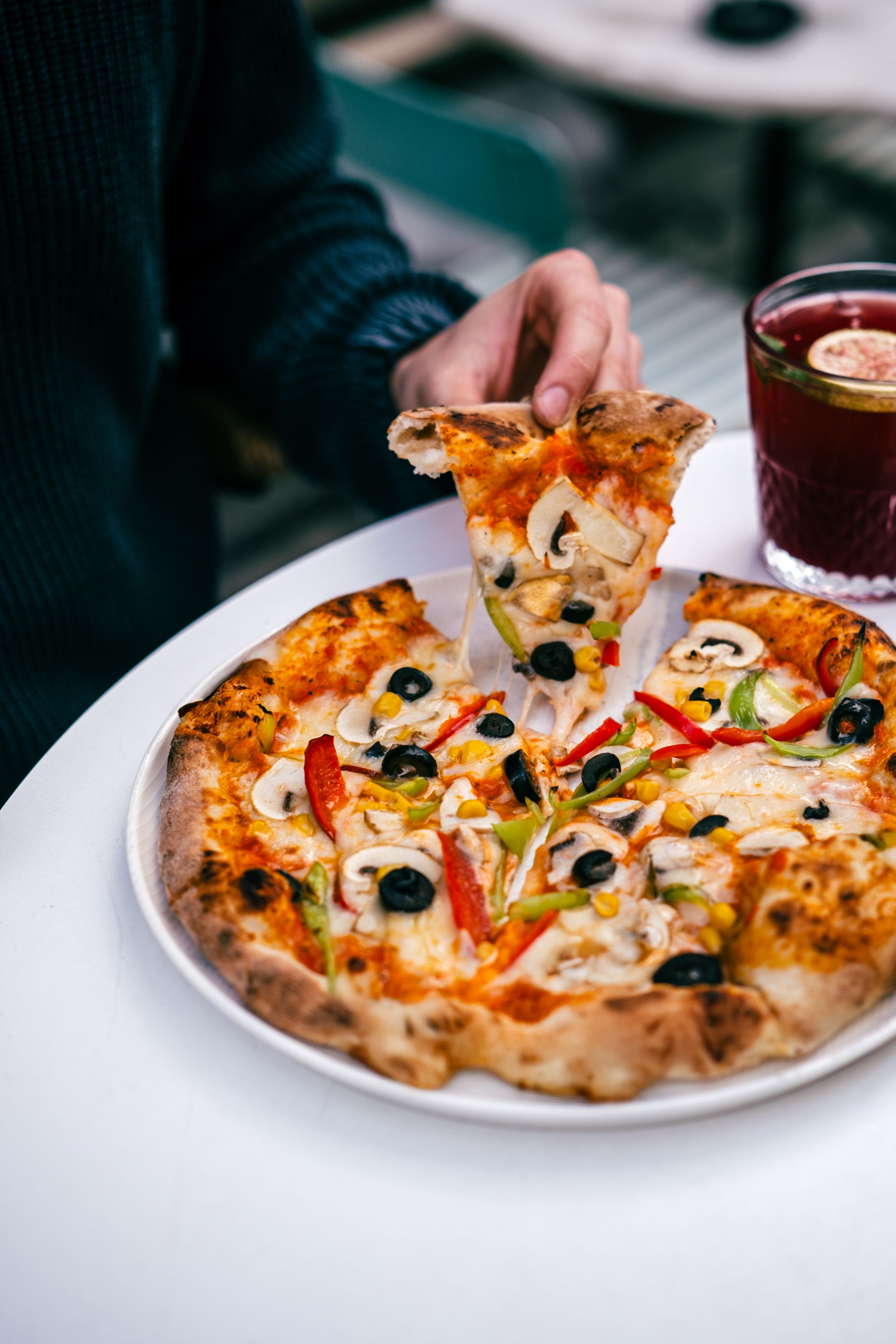 Delicious Veggie Pizza Slice in Urban Café · Free Stock Photo