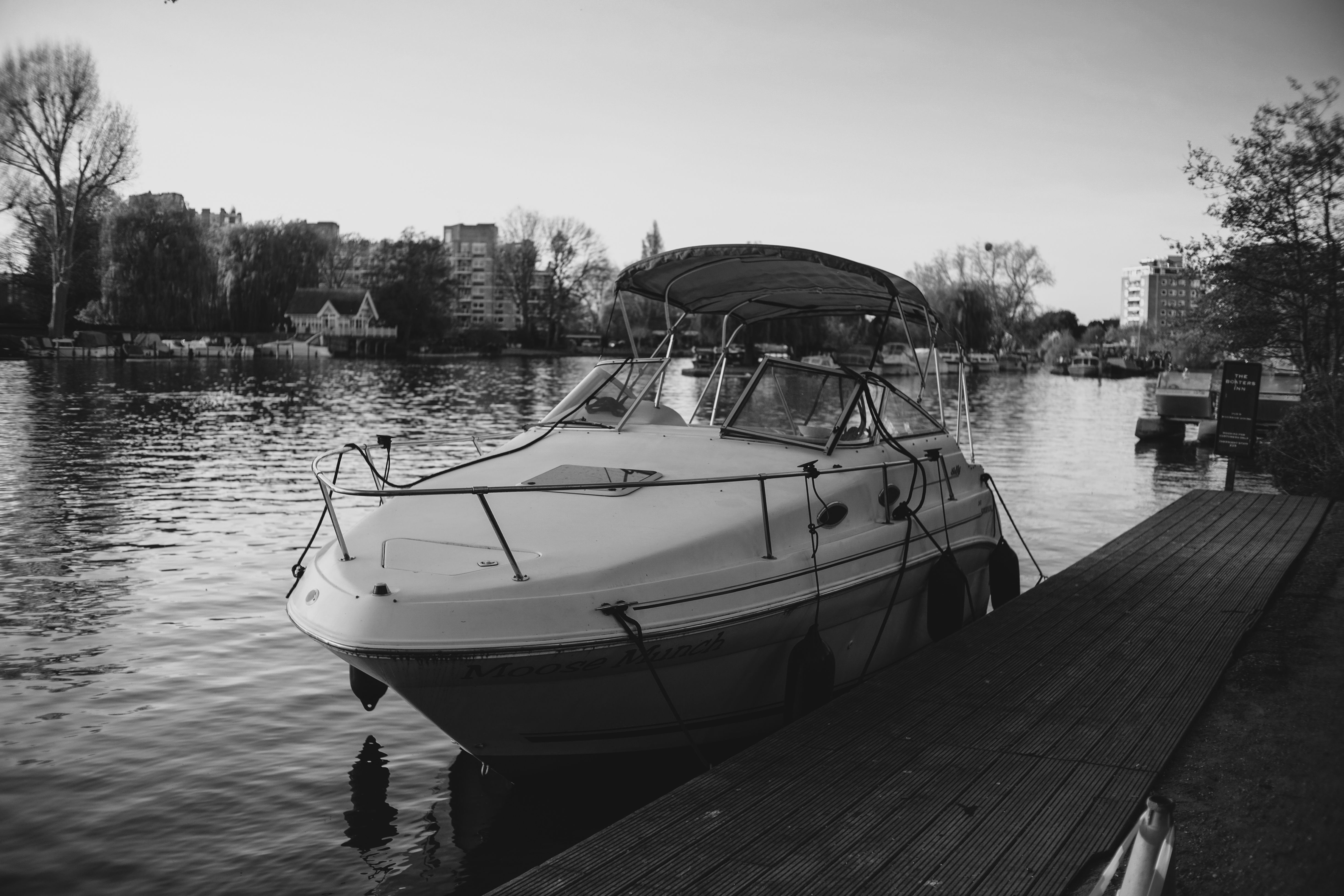 Boat Docked at Scenic Waterfront in Black and White · Free Stock Photo