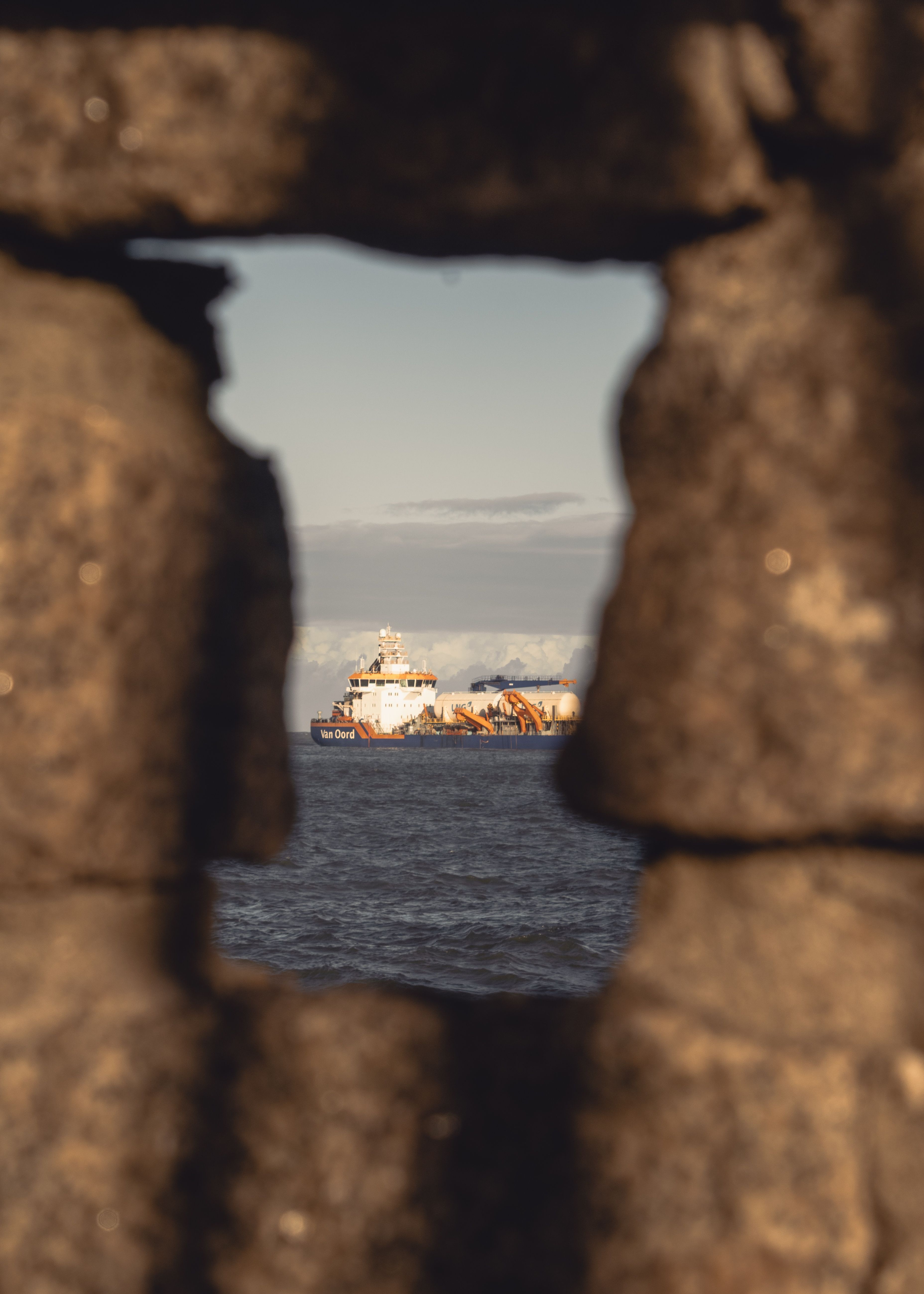 Cargo Ship Framed by Stone Wall · Free Stock Photo