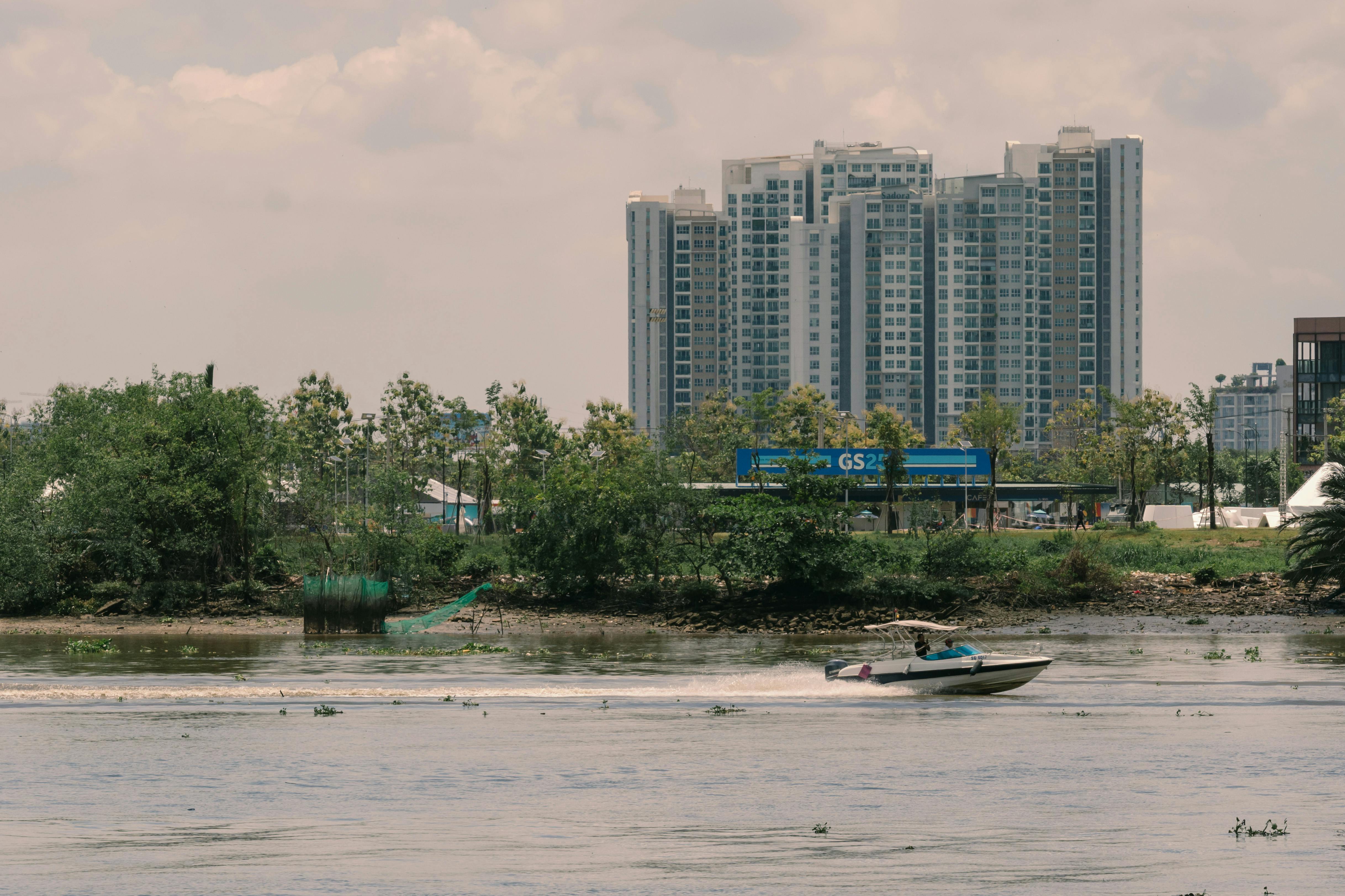 Speedboat cruising past urban waterfront scenery · Free Stock Photo