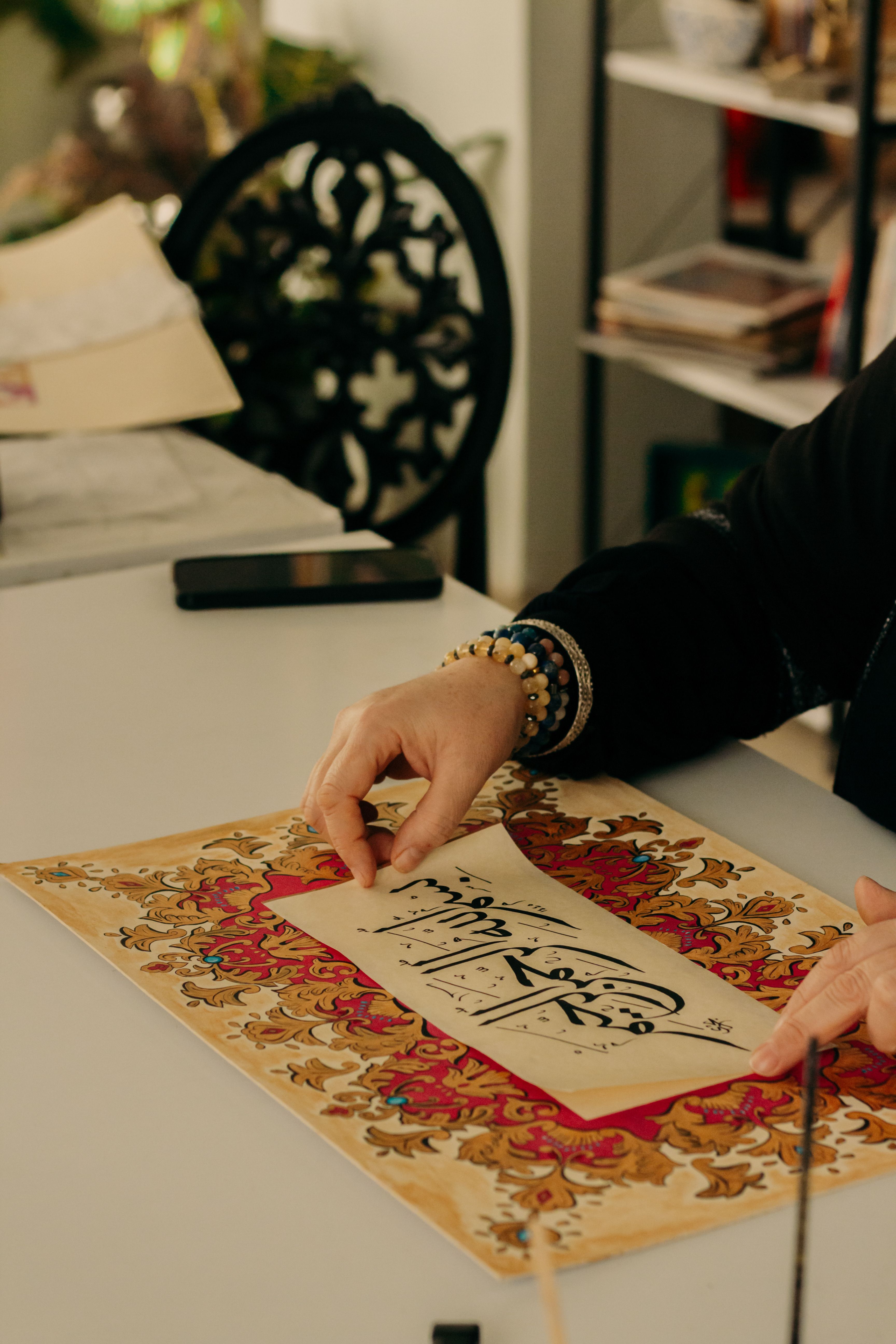 Woman Creating Decorative Arabic Calligraphy on Table · Free Stock Photo