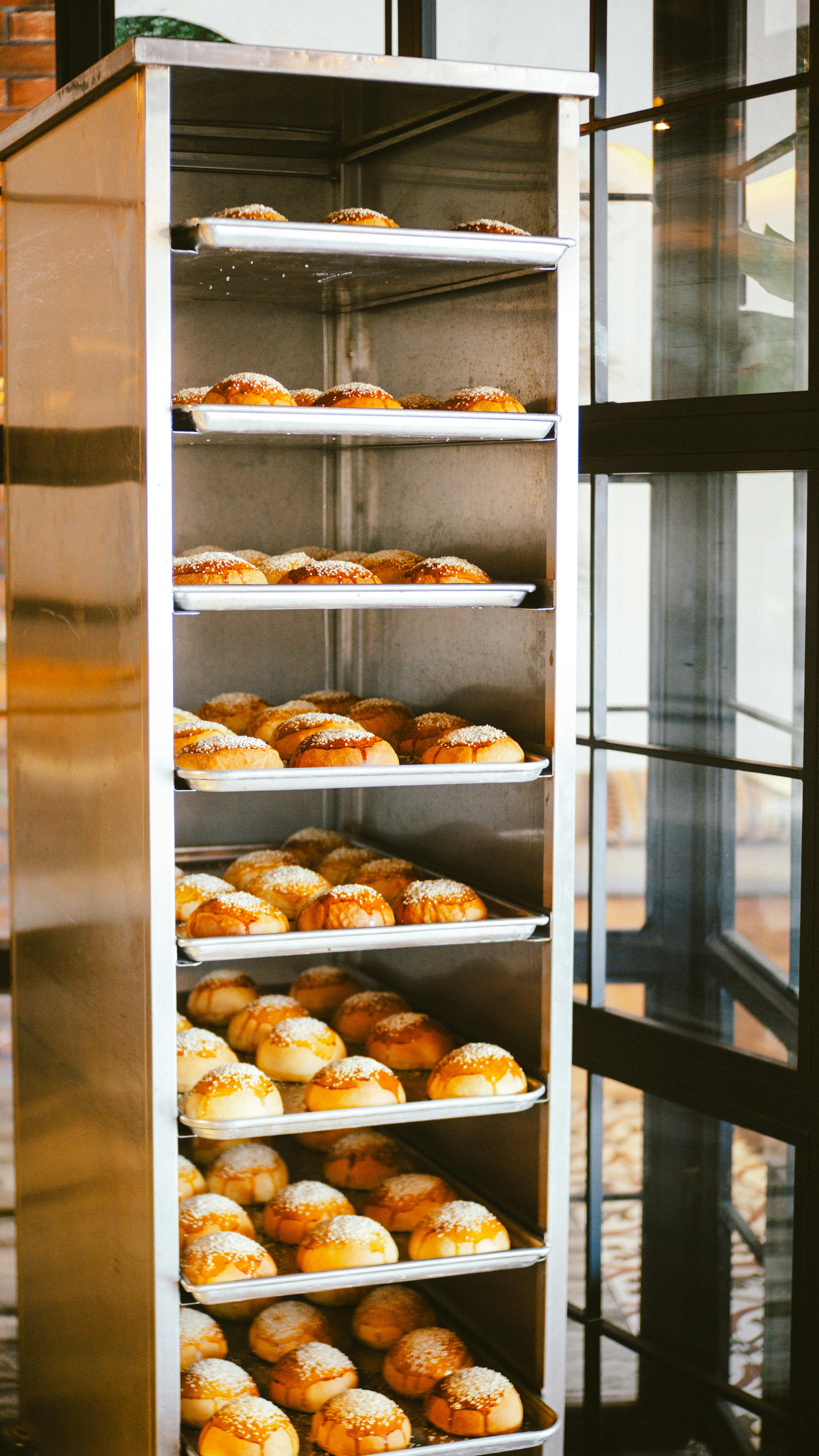 Stack of Freshly Baked Bread Rolls on Rack · Free Stock Photo