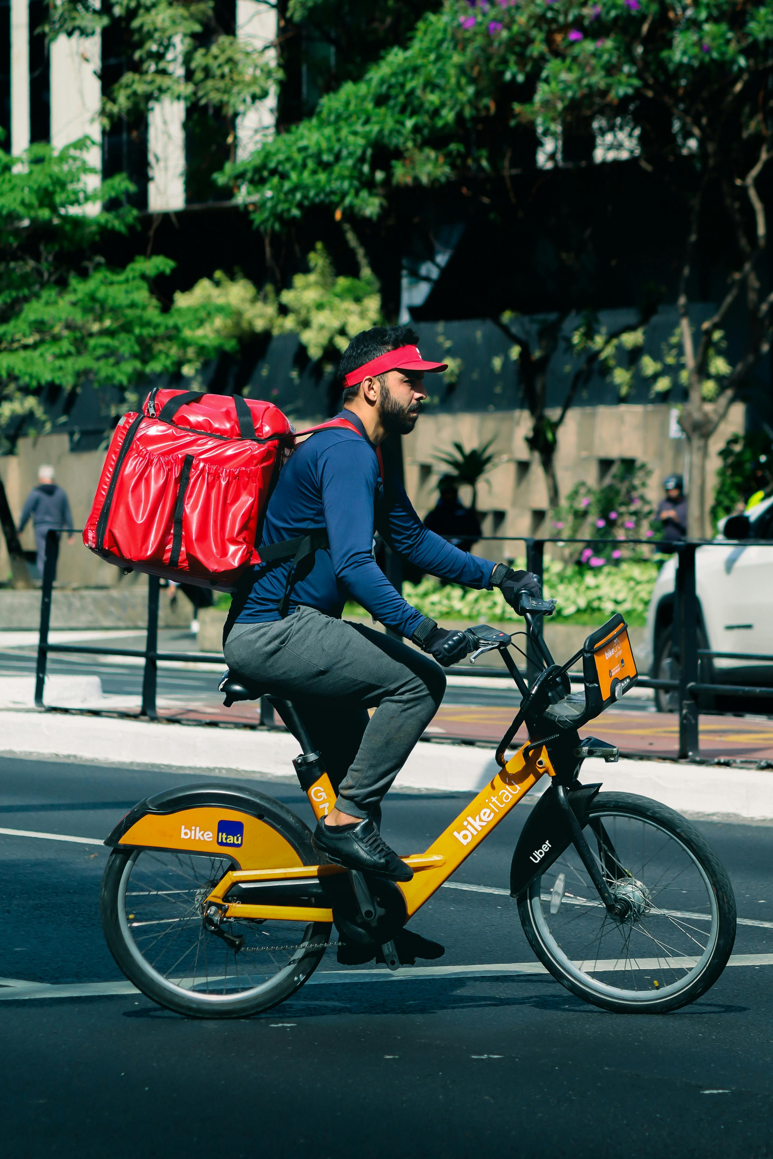 Food Delivery Cyclist Riding Through City Street · Free Stock Photo