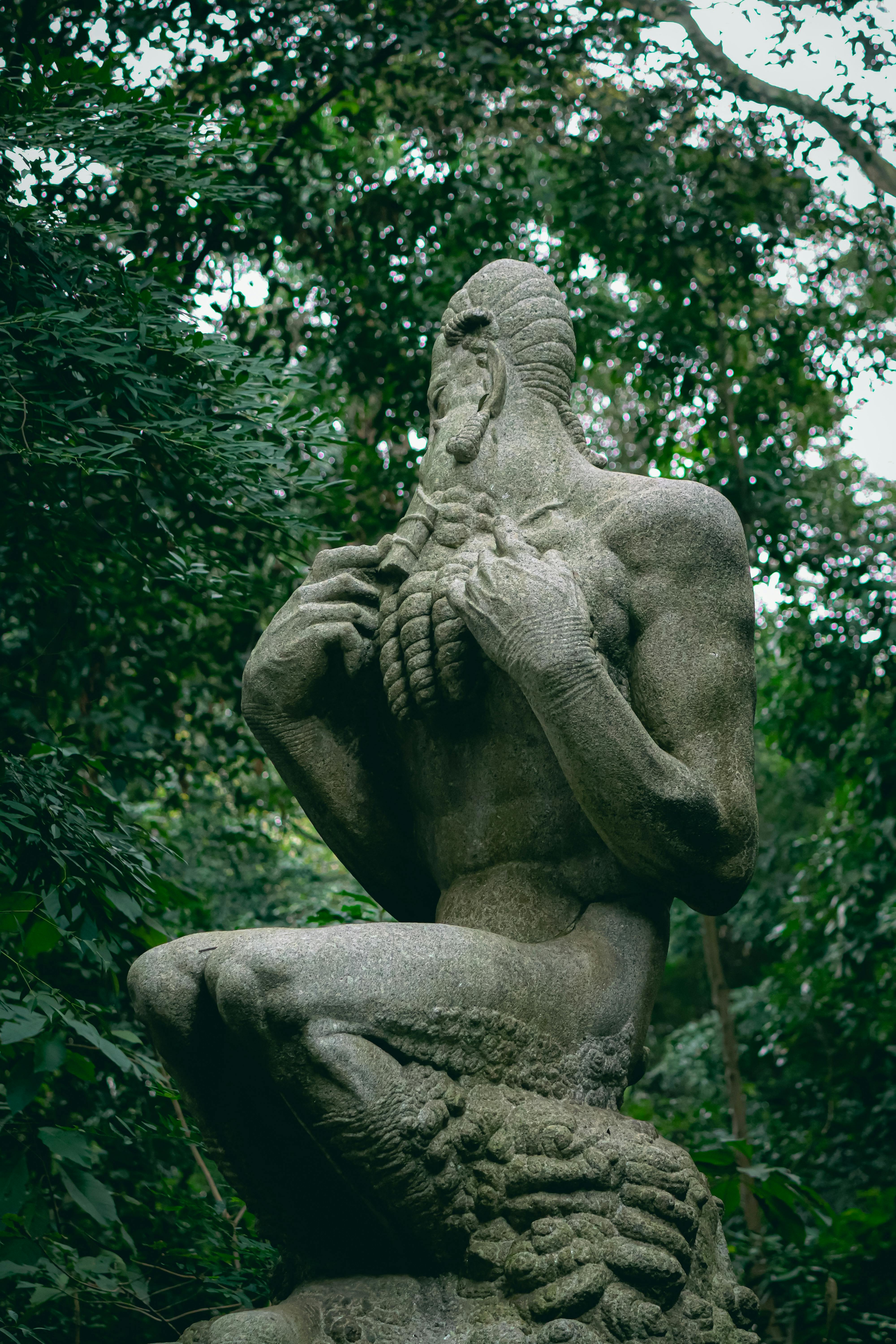Stone Mythical Creature Statue in Lush Forest · Free Stock Photo