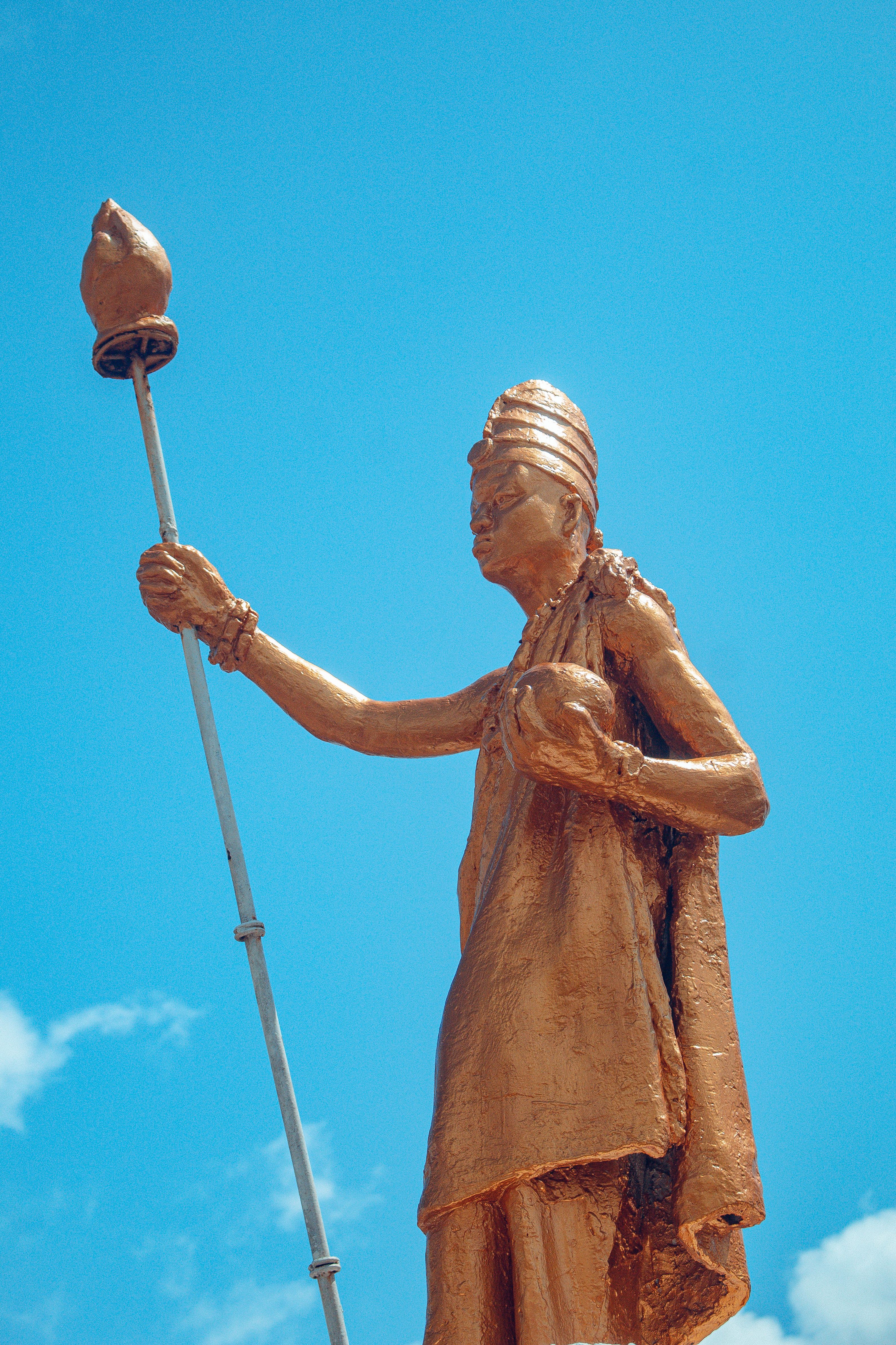 Golden Statue of Historical Figure Against Blue Sky · Free Stock Photo
