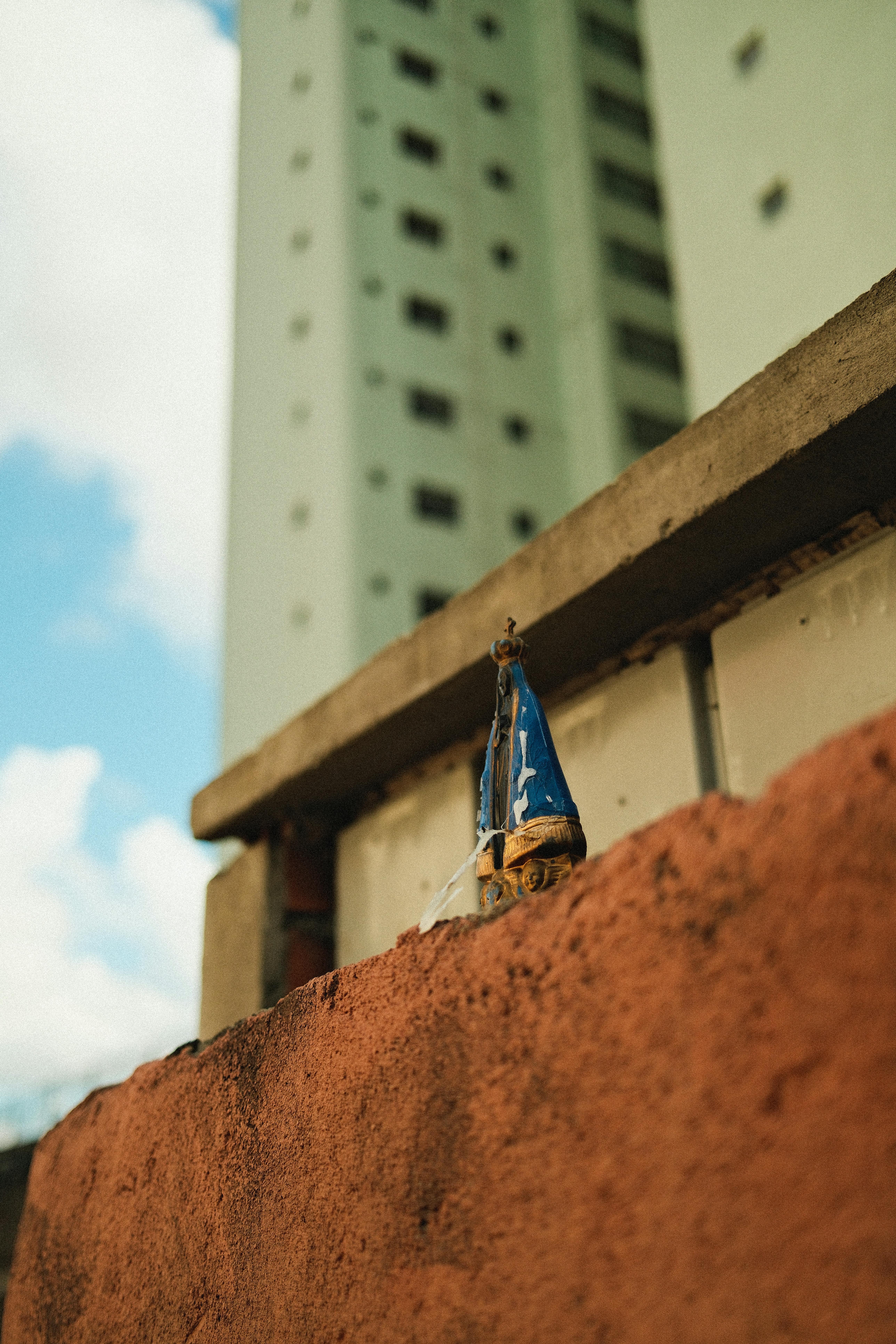 Miniature Wizard Hat on a Wall with Building · Free Stock Photo