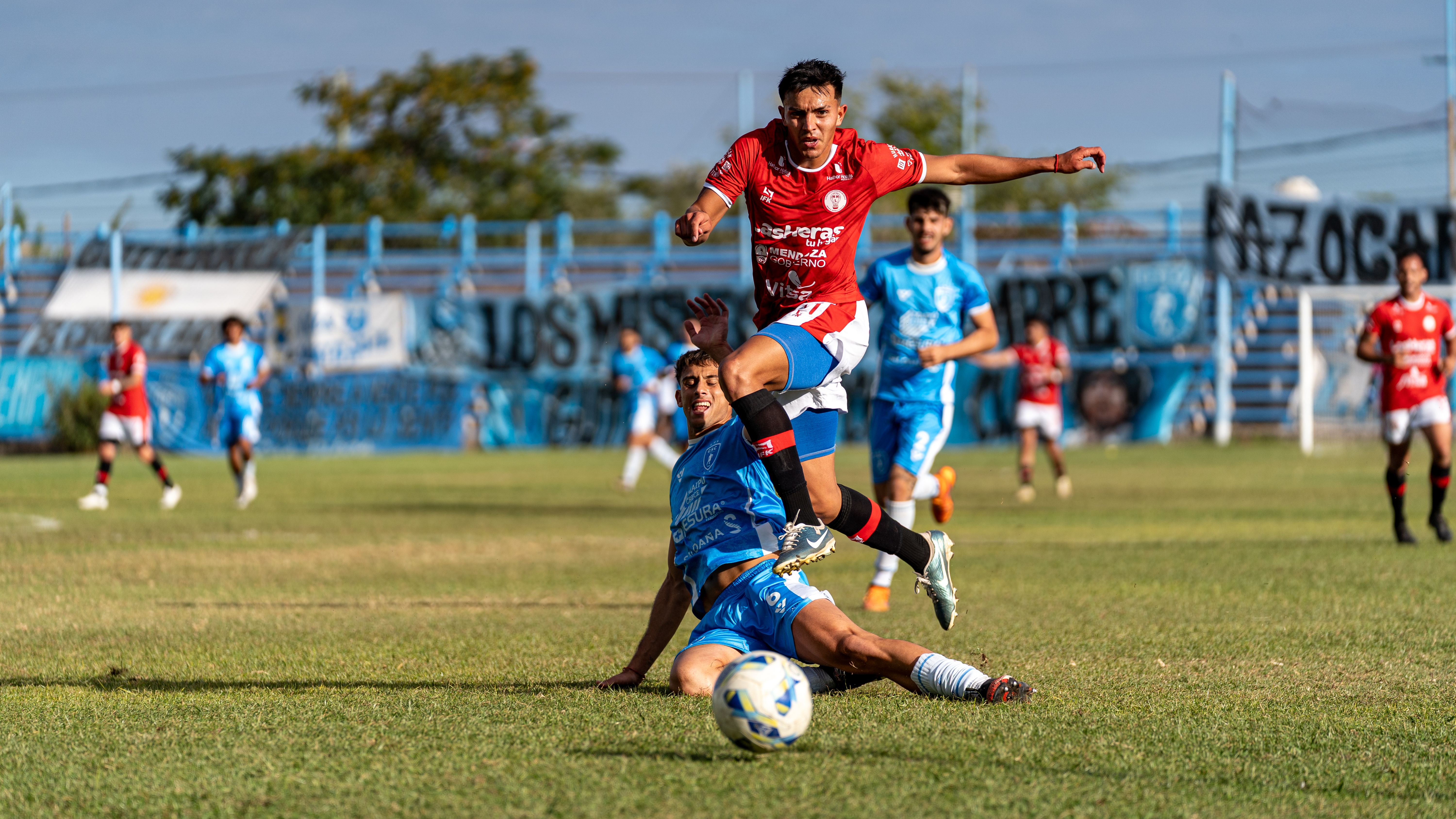 Intense Soccer Match with Players in Mid-Air Action · Free Stock Photo