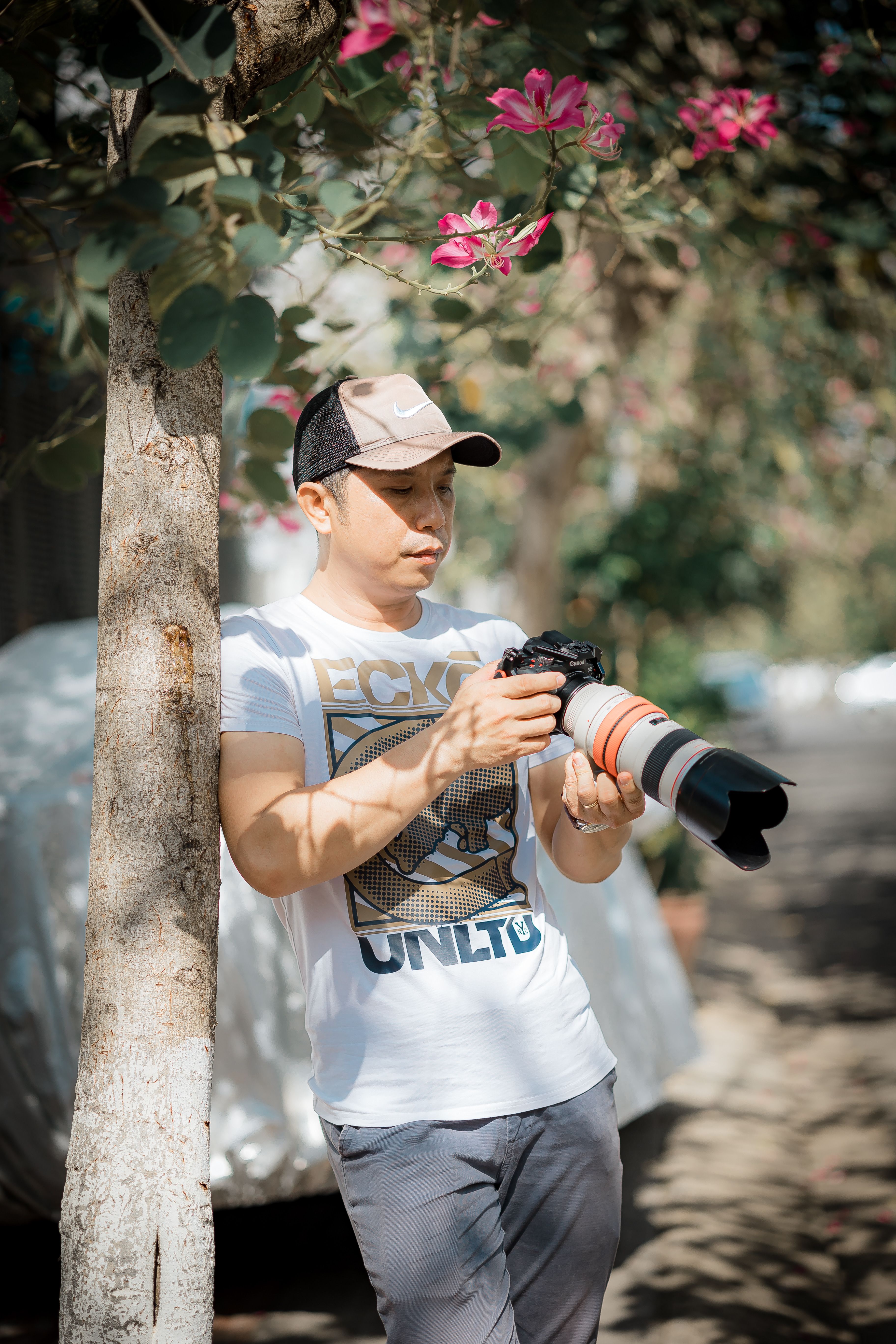 Photographer Holding Camera in Outdoor Setting · Free Stock Photo