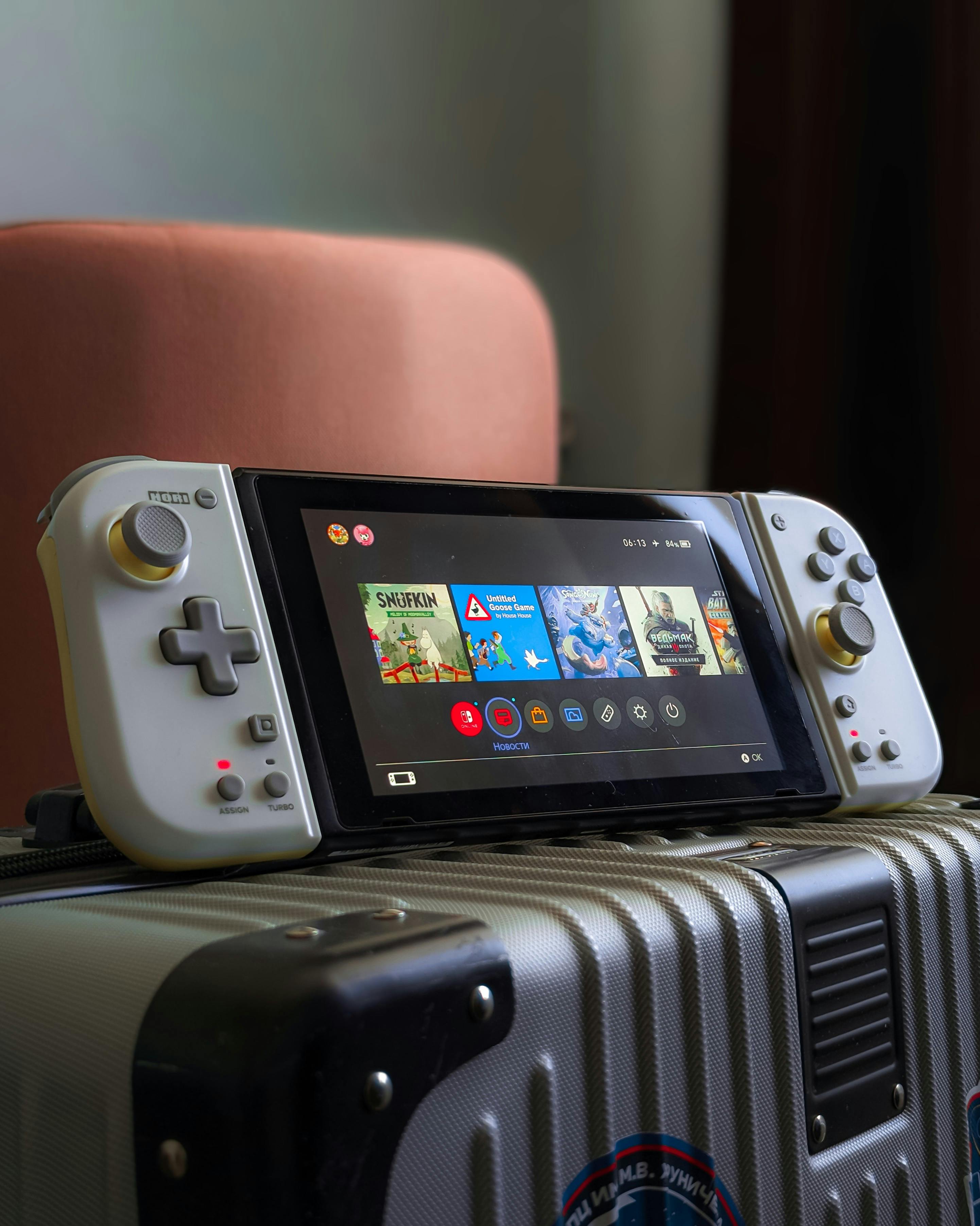 Handheld gaming console on suitcase indoors · Free Stock Photo