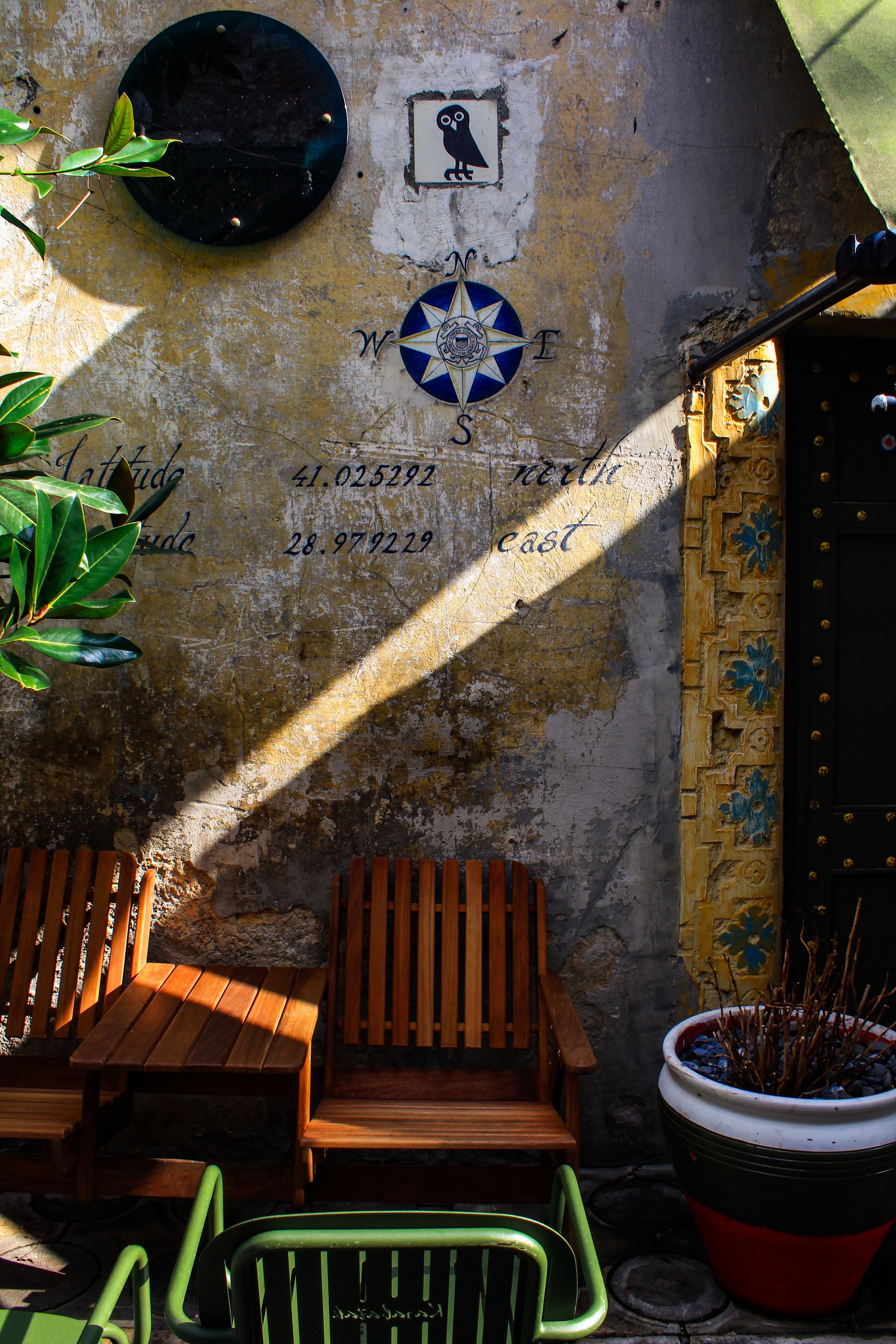 Vintage Courtyard with Compass and Wooden Chairs · Free Stock Photo