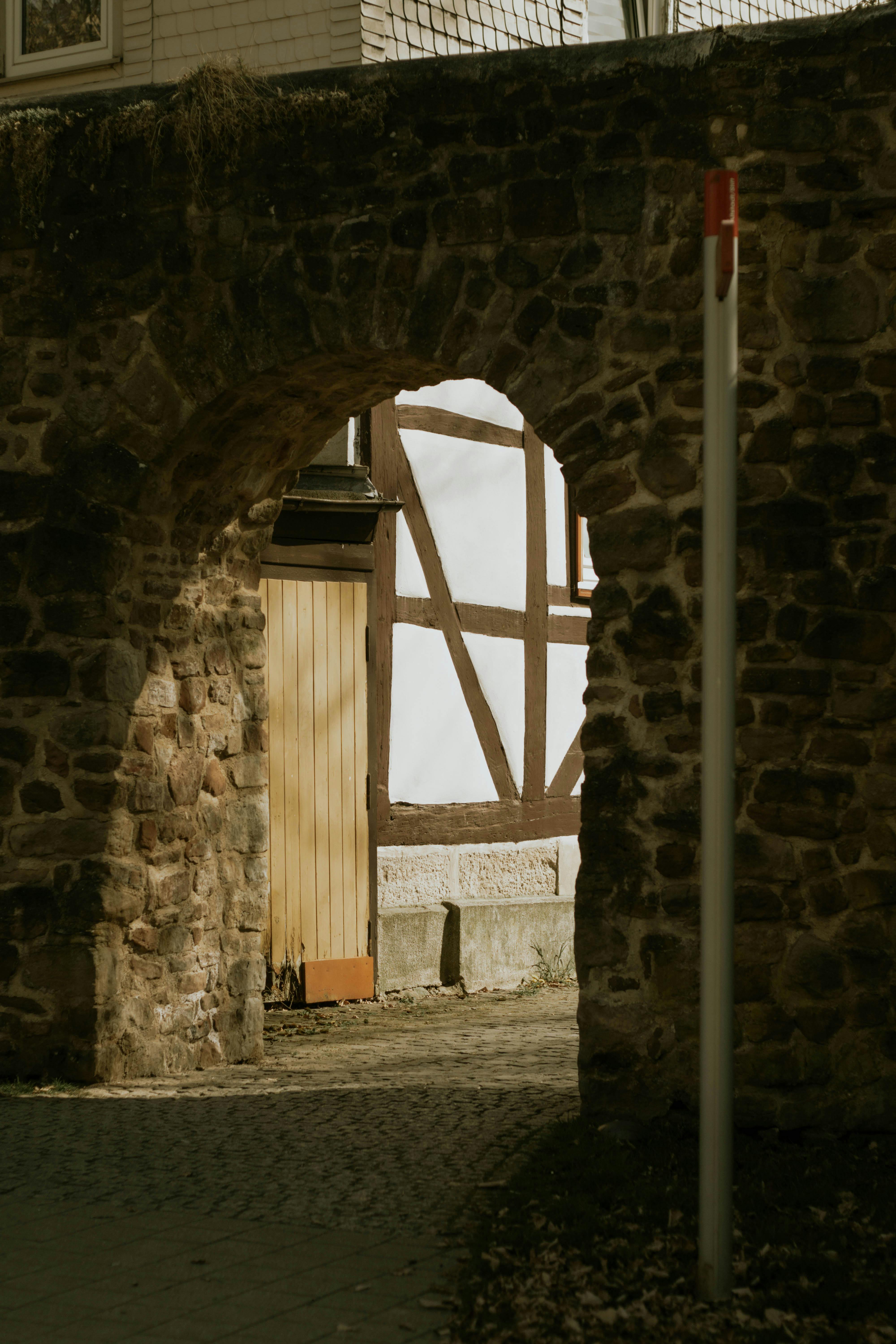 Timber Framed Archway in Historic Stone Wall · Free Stock Photo