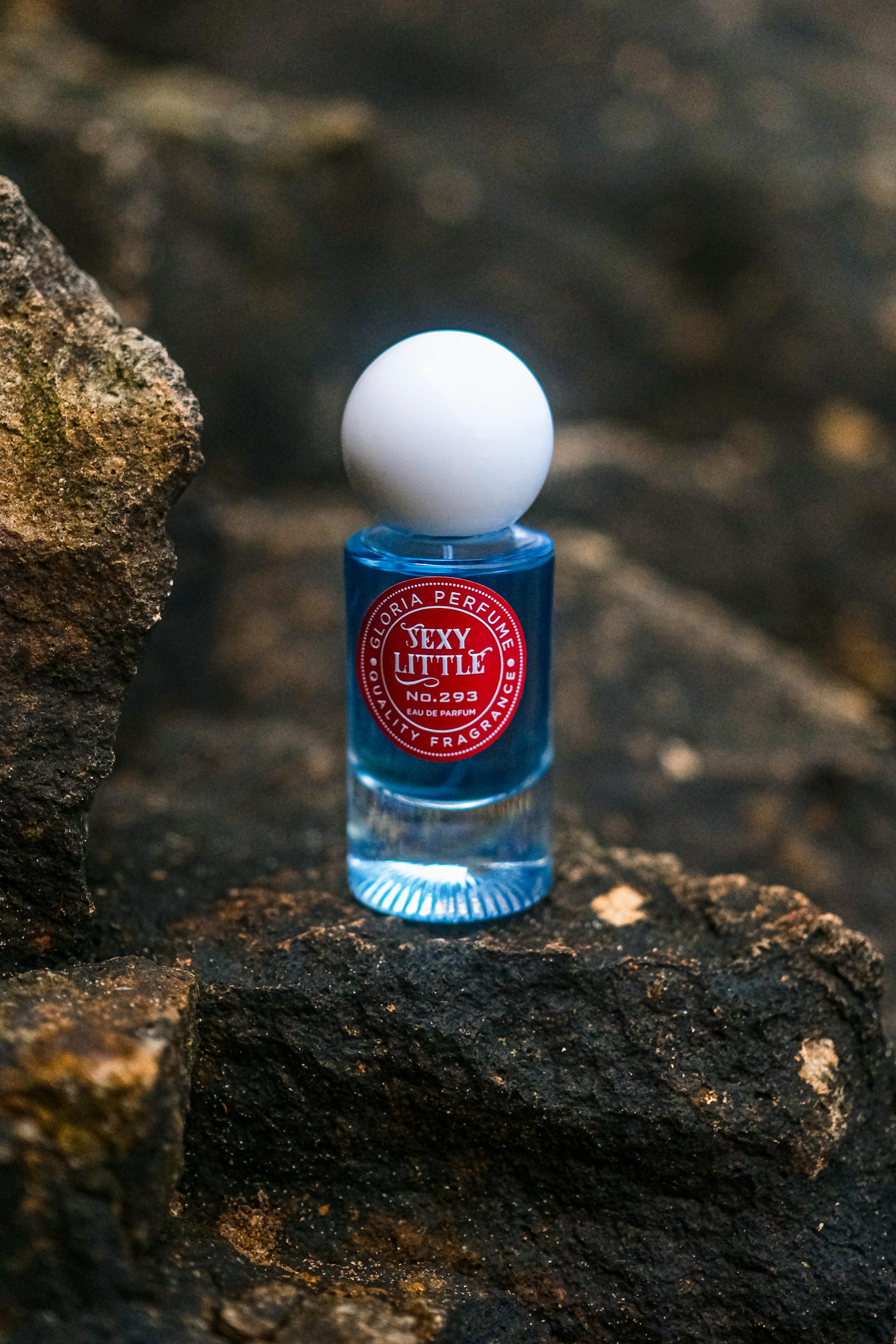 Blue Perfume Bottle on Rustic Stone Surface · Free Stock Photo