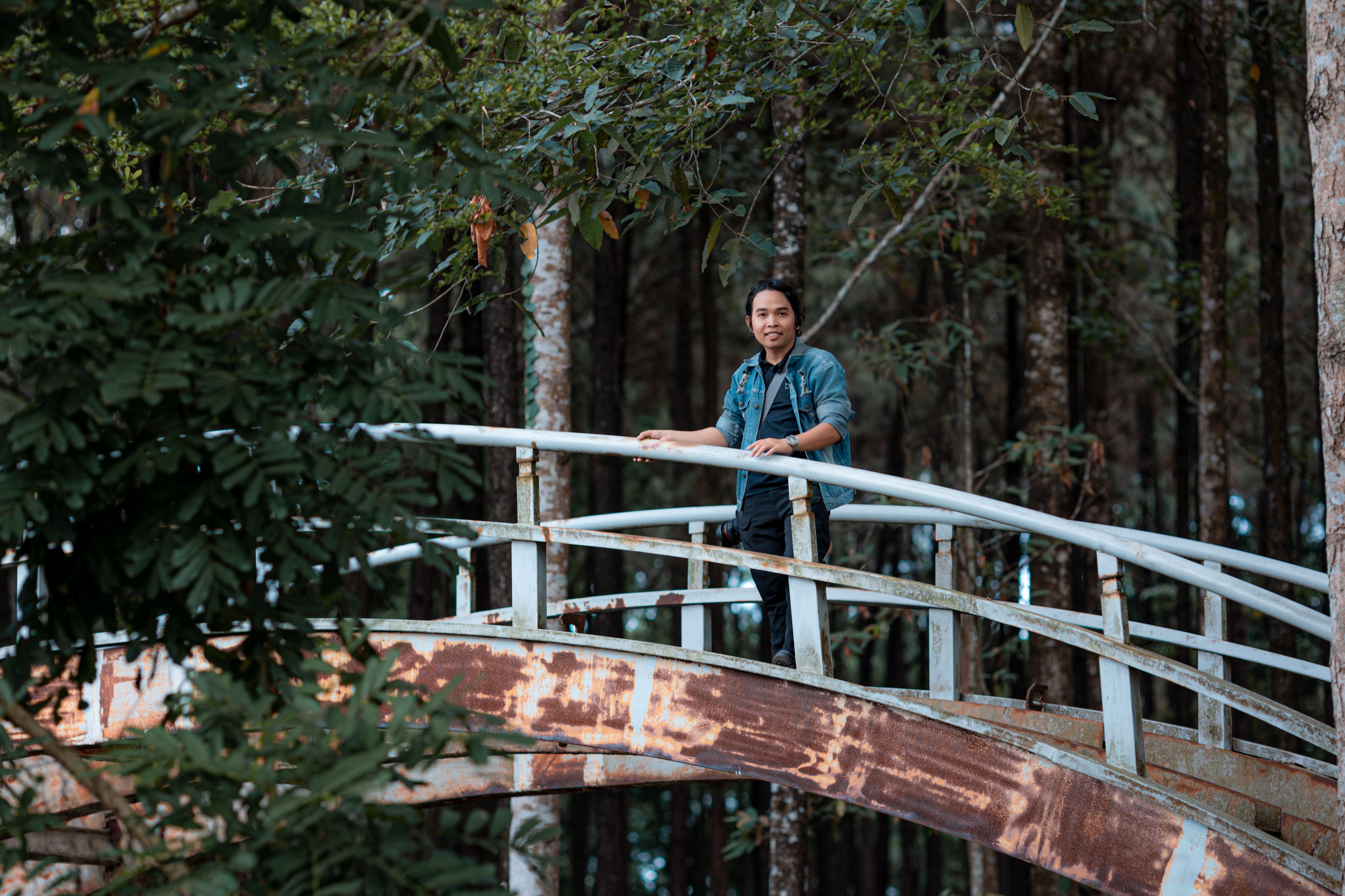Man Standing on Rustic Bridge in Vietnamese Forest · Free Stock Photo