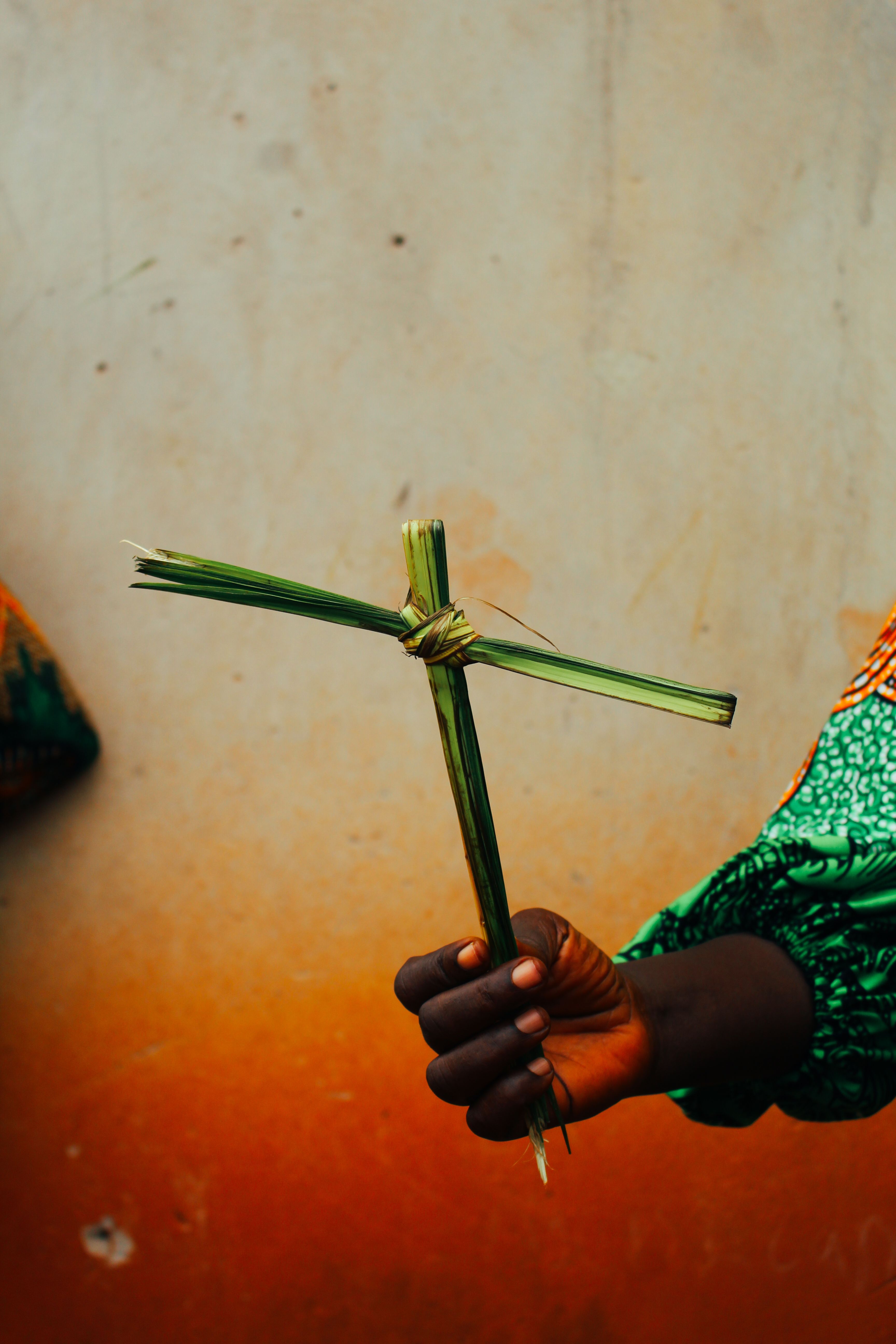 Palm Cross Held by Person in Traditional Attire · Free Stock Photo