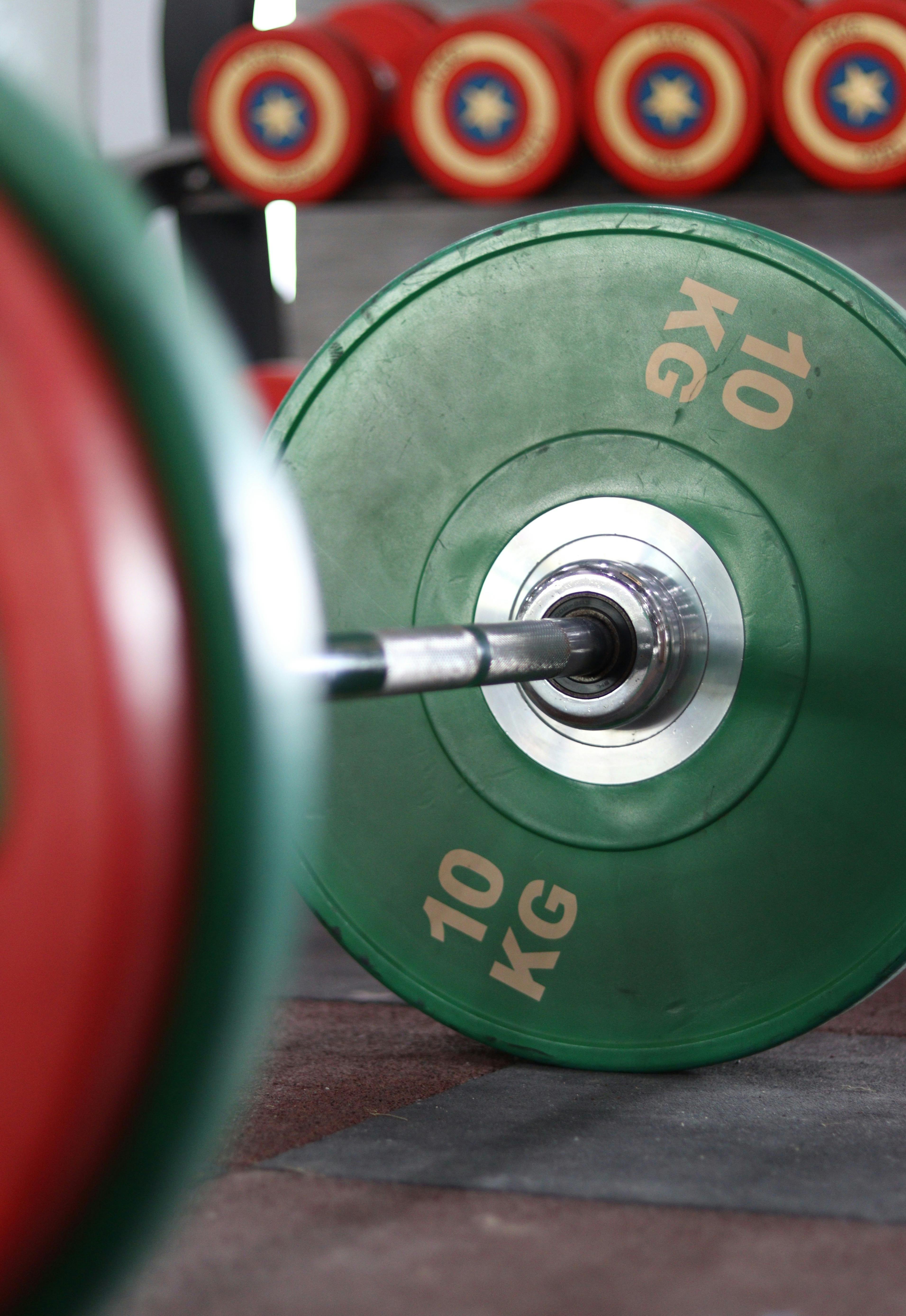 Groene Gewichtsschijf Op Halter In De Sportschool · Gratis stockfoto