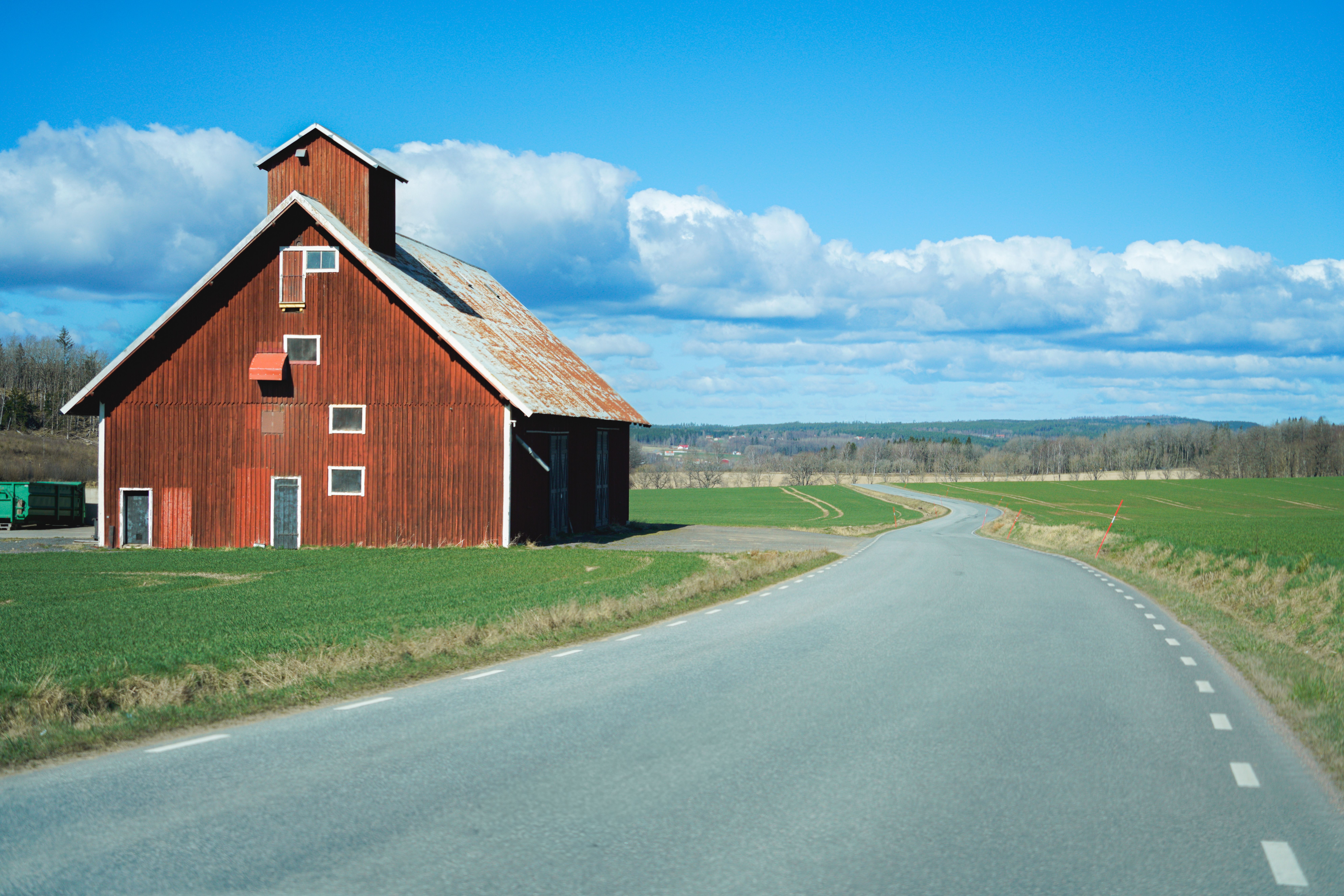 Scenic Rural Barn Along a Winding Road · Free Stock Photo