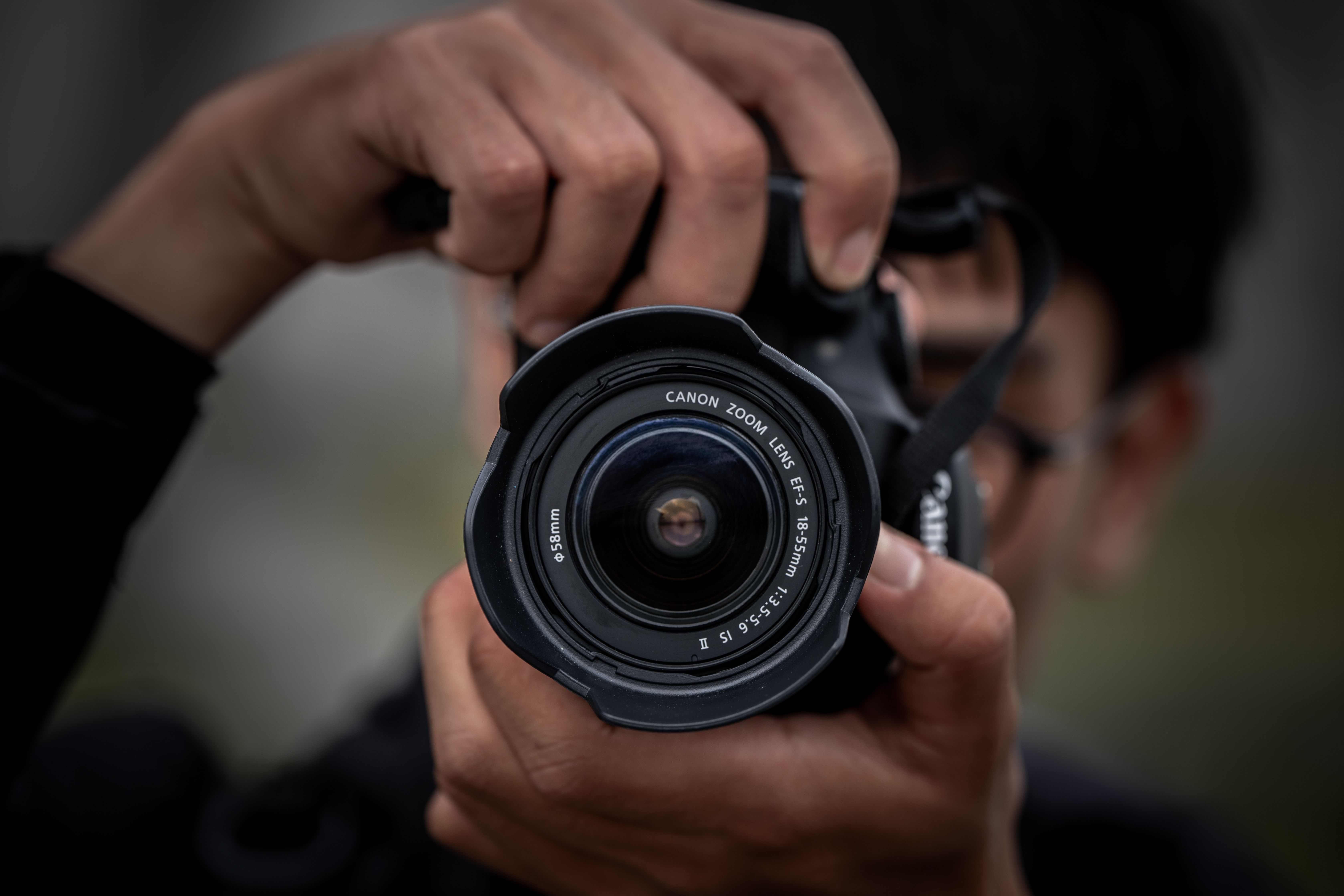 Close-Up of Photographer Holding Camera Lens · Free Stock Photo
