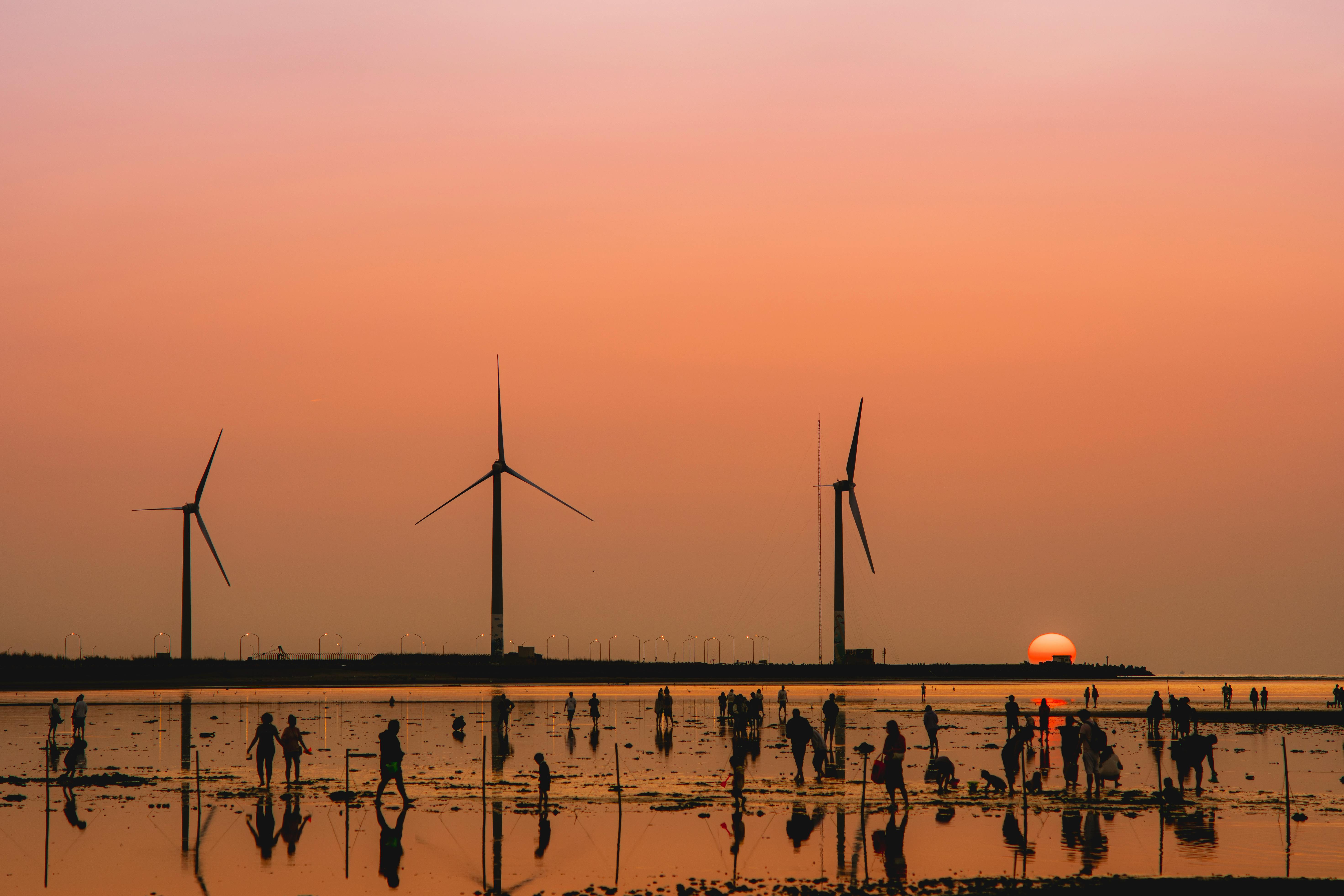 Taiwanese Wind Farm Sunset with Silhouetted Visitors · Free Stock Photo