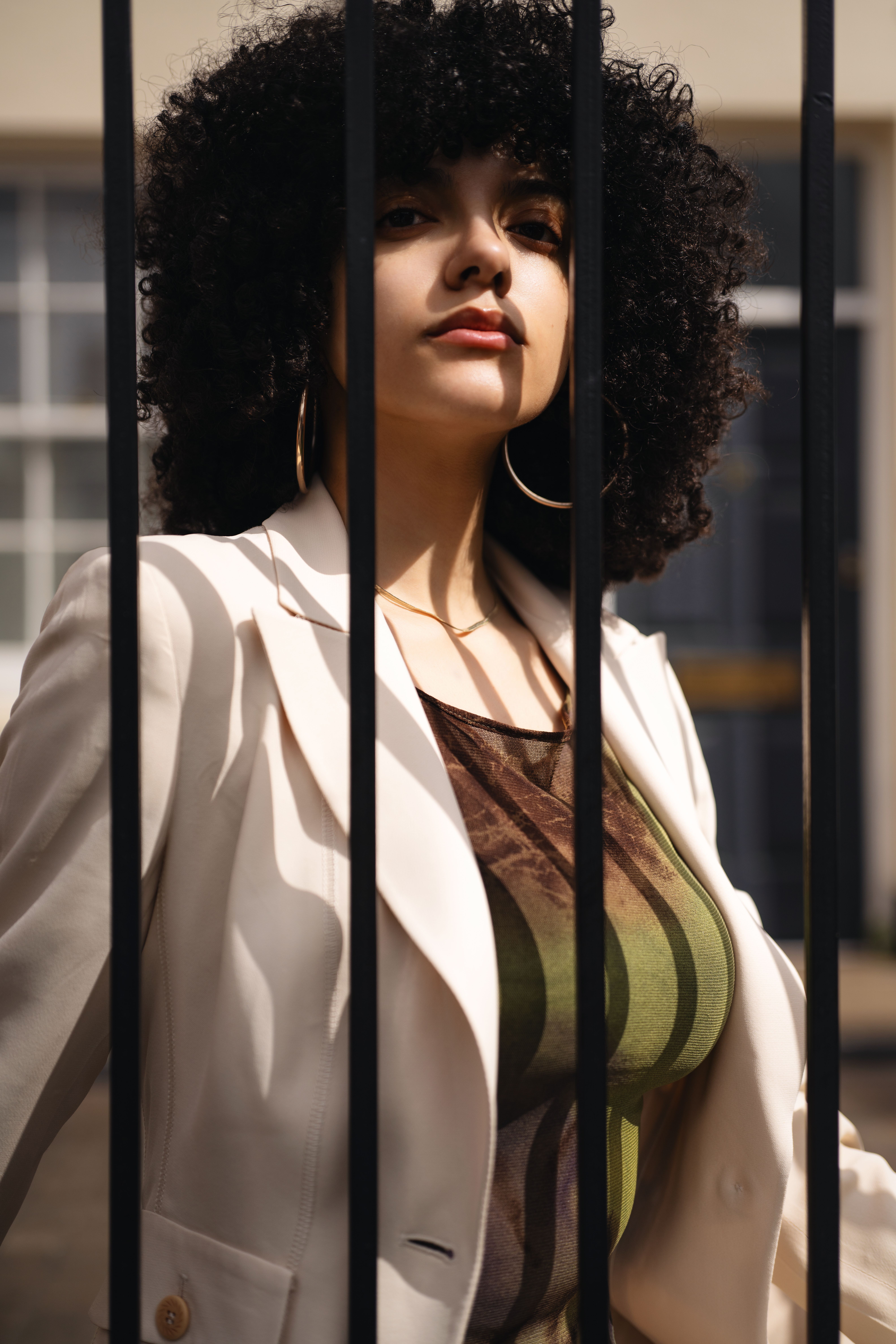 Chic Portrait of Woman in White Blazer Behind Bars · Free Stock Photo
