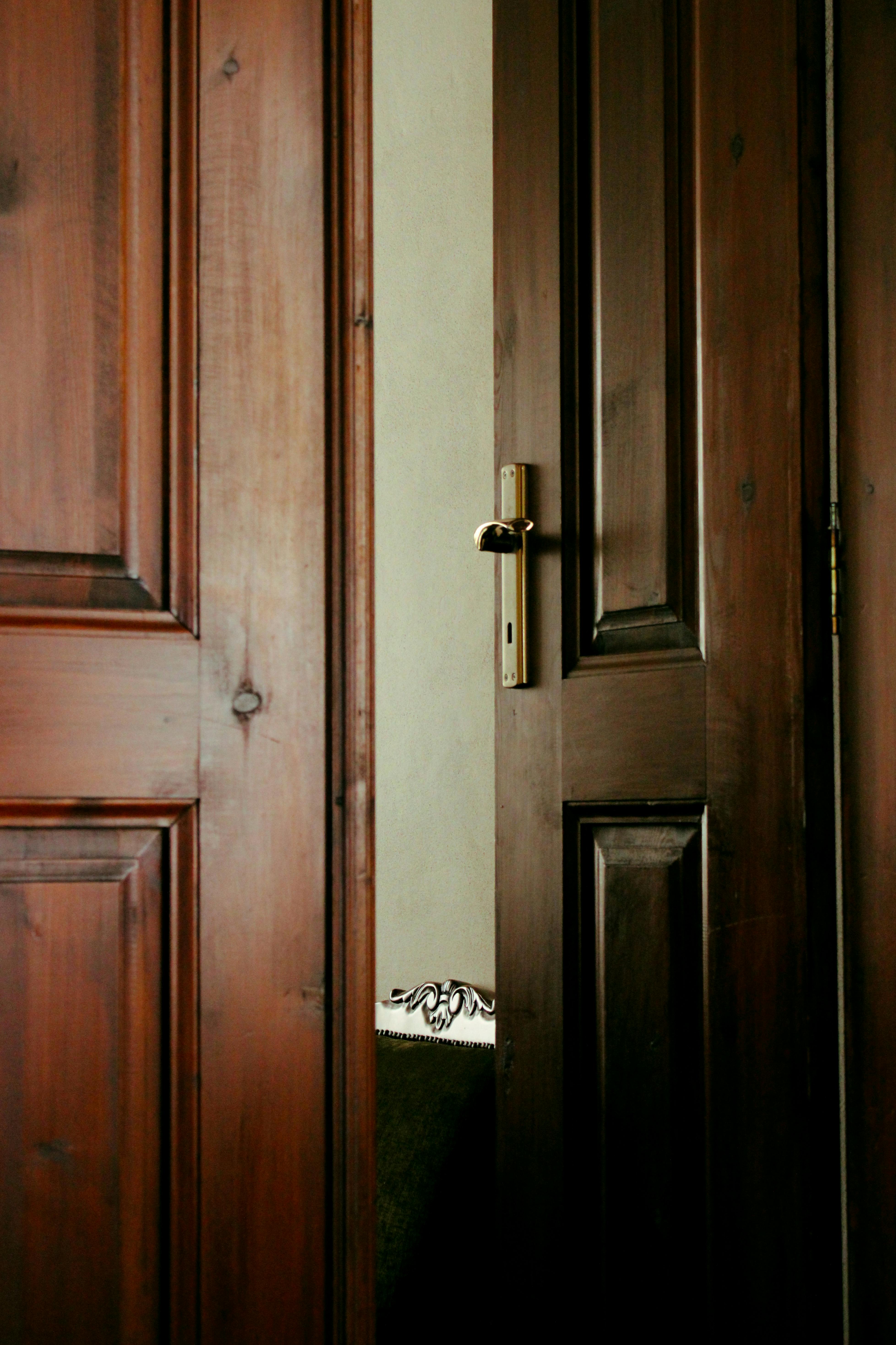Partially Open Wooden Door Revealing Patterned Wall · Free Stock Photo