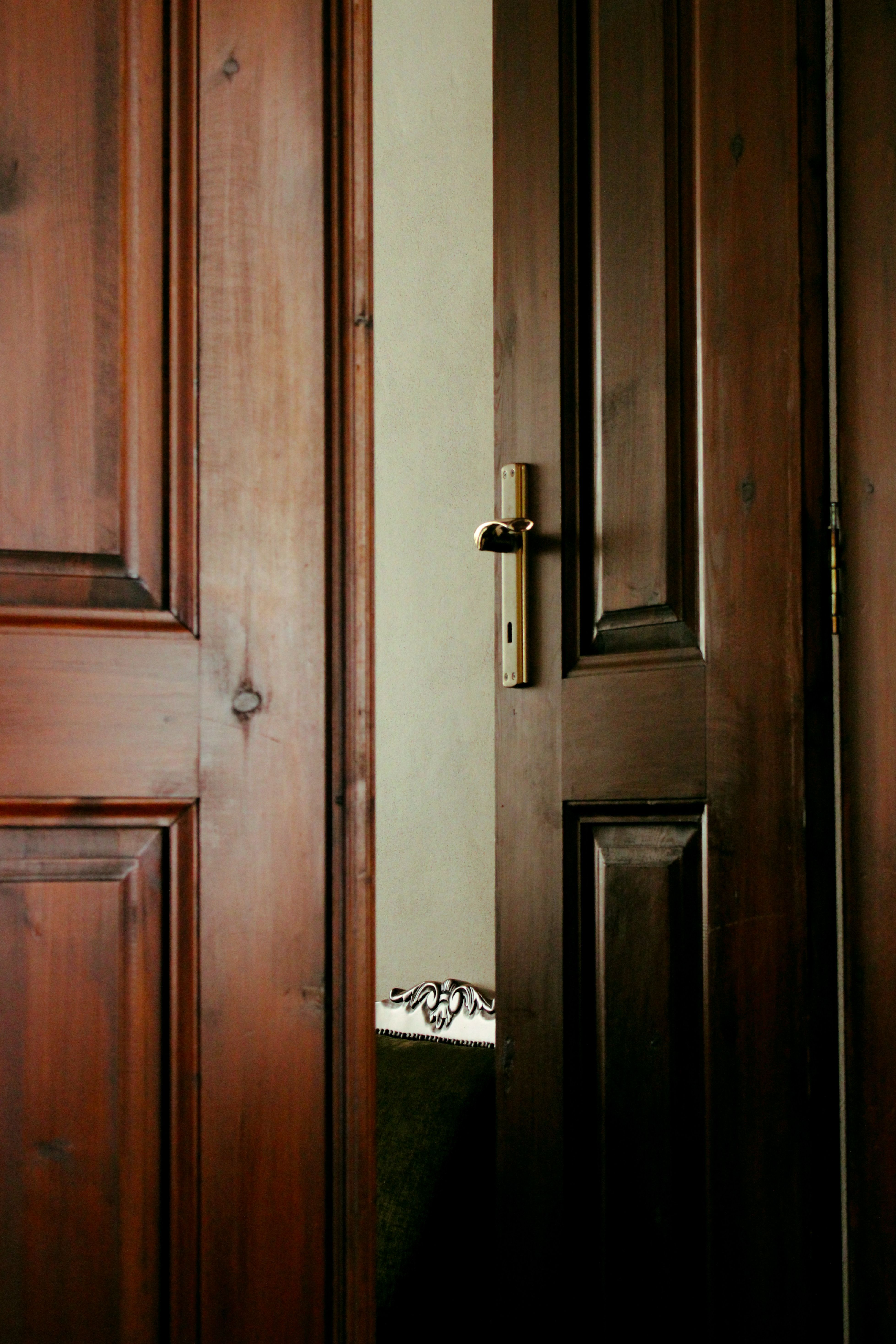 Partially Open Wooden Door Revealing Patterned Wall · Free Stock Photo