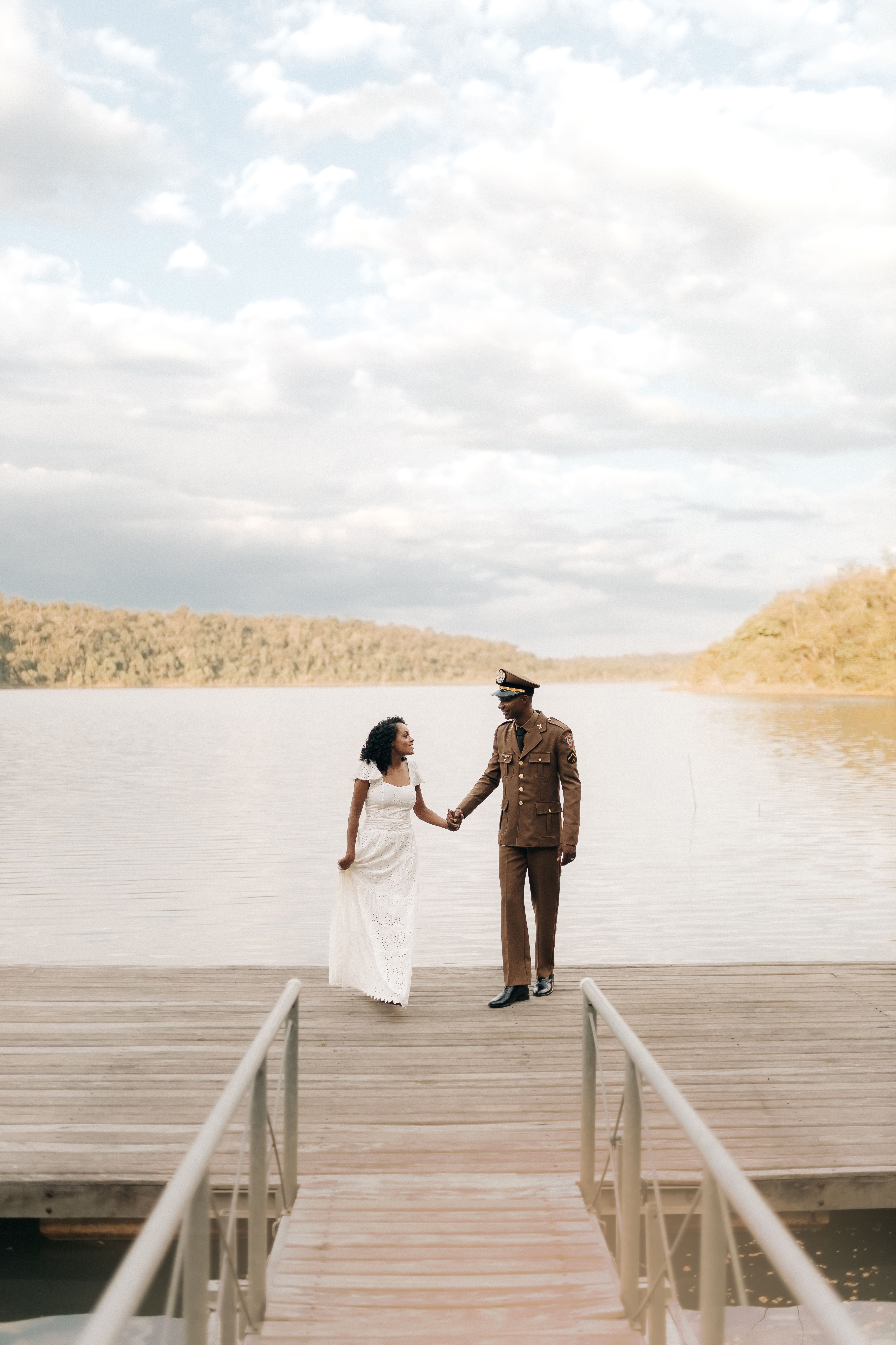 Romantic Couple Holding Hands by a Lake Dock · Free Stock Photo