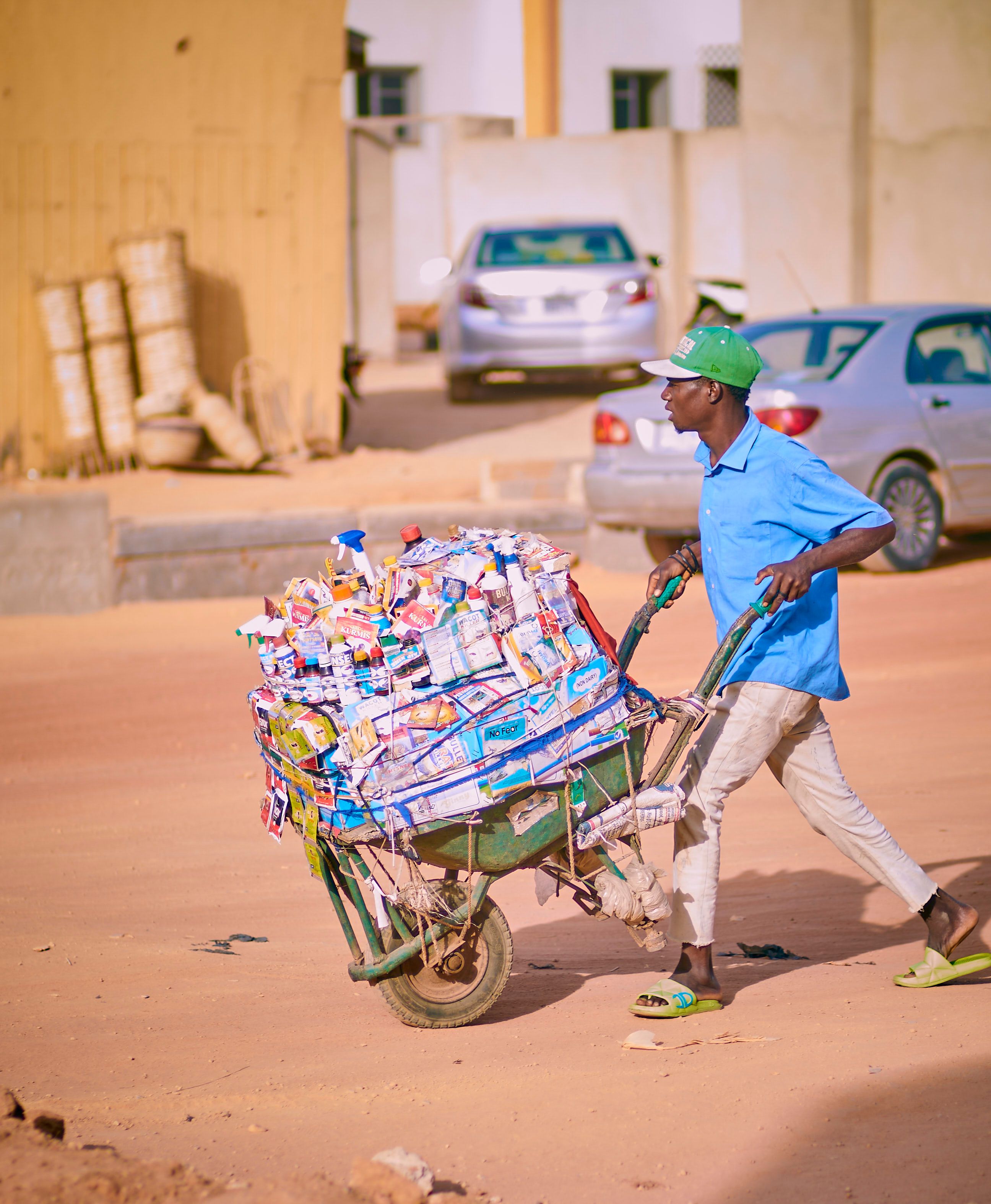 Man Pushing Cart of Recyclable Materials on Street · Free Stock Photo