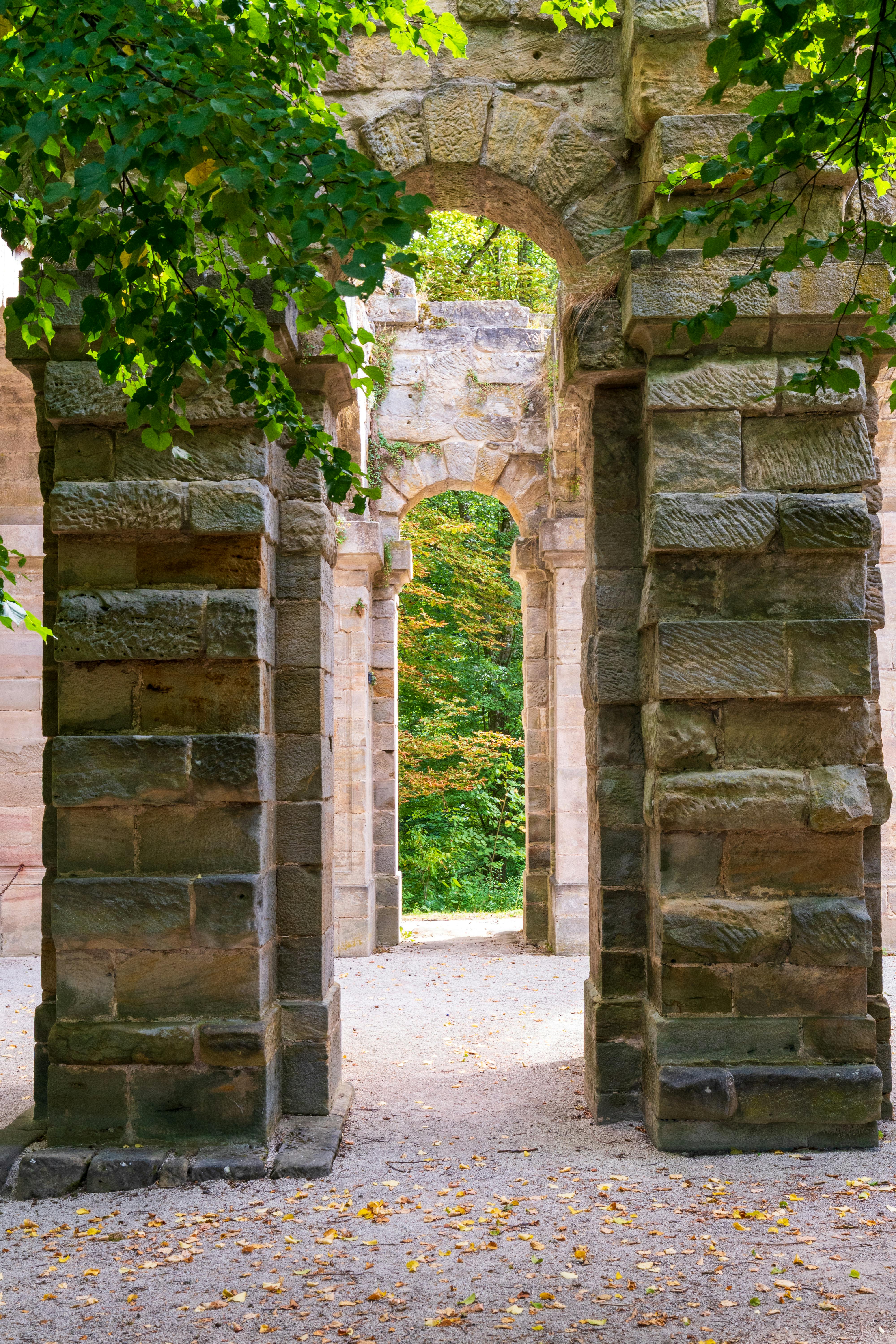 Ancient Stone Arches Amid Lush Foliage · Free Stock Photo